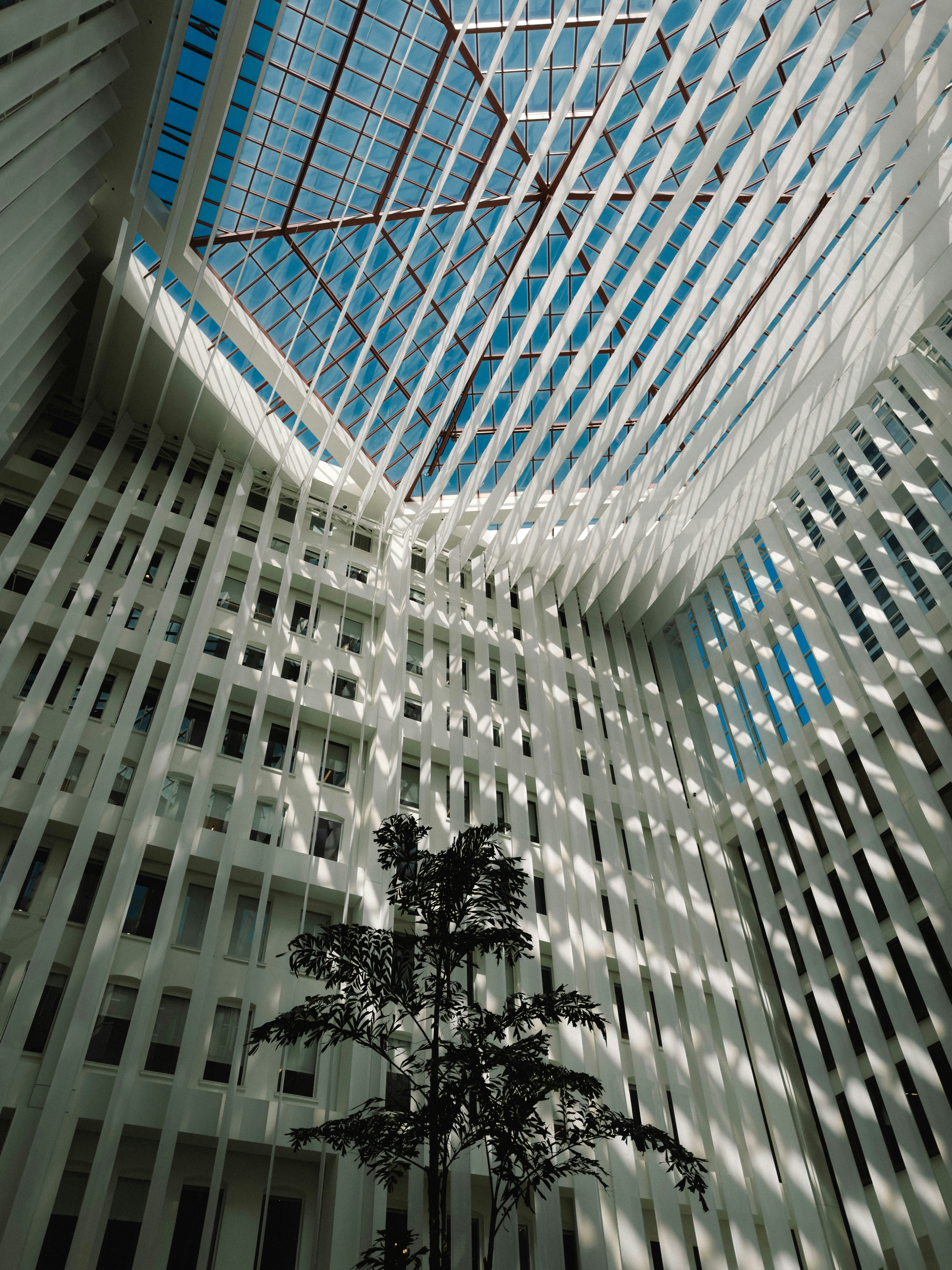Skyward Atrium: Light Stripes Across a Modern Court
