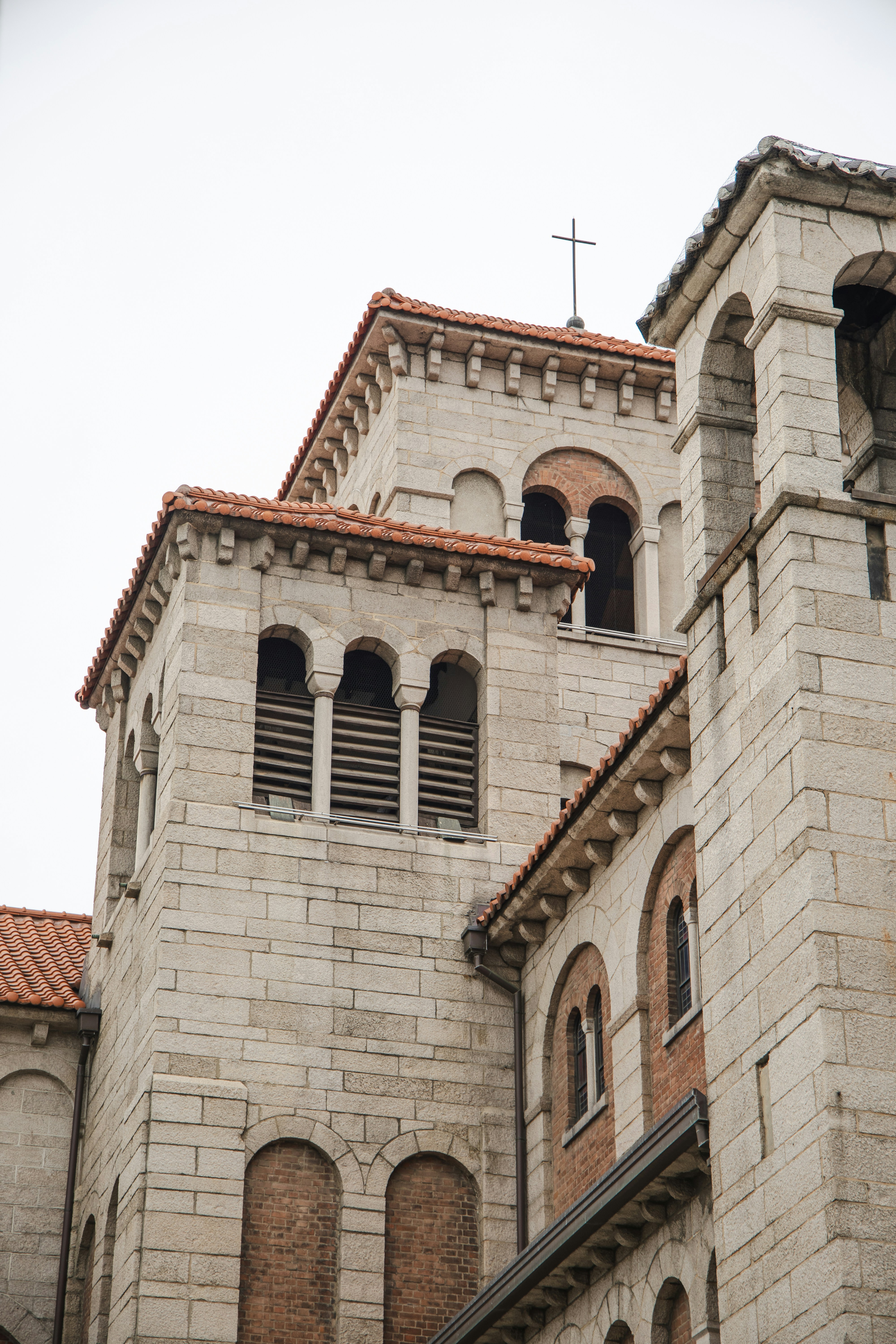 Stone Lanterns and Cross: A Close-Up of a Cathedral Tower