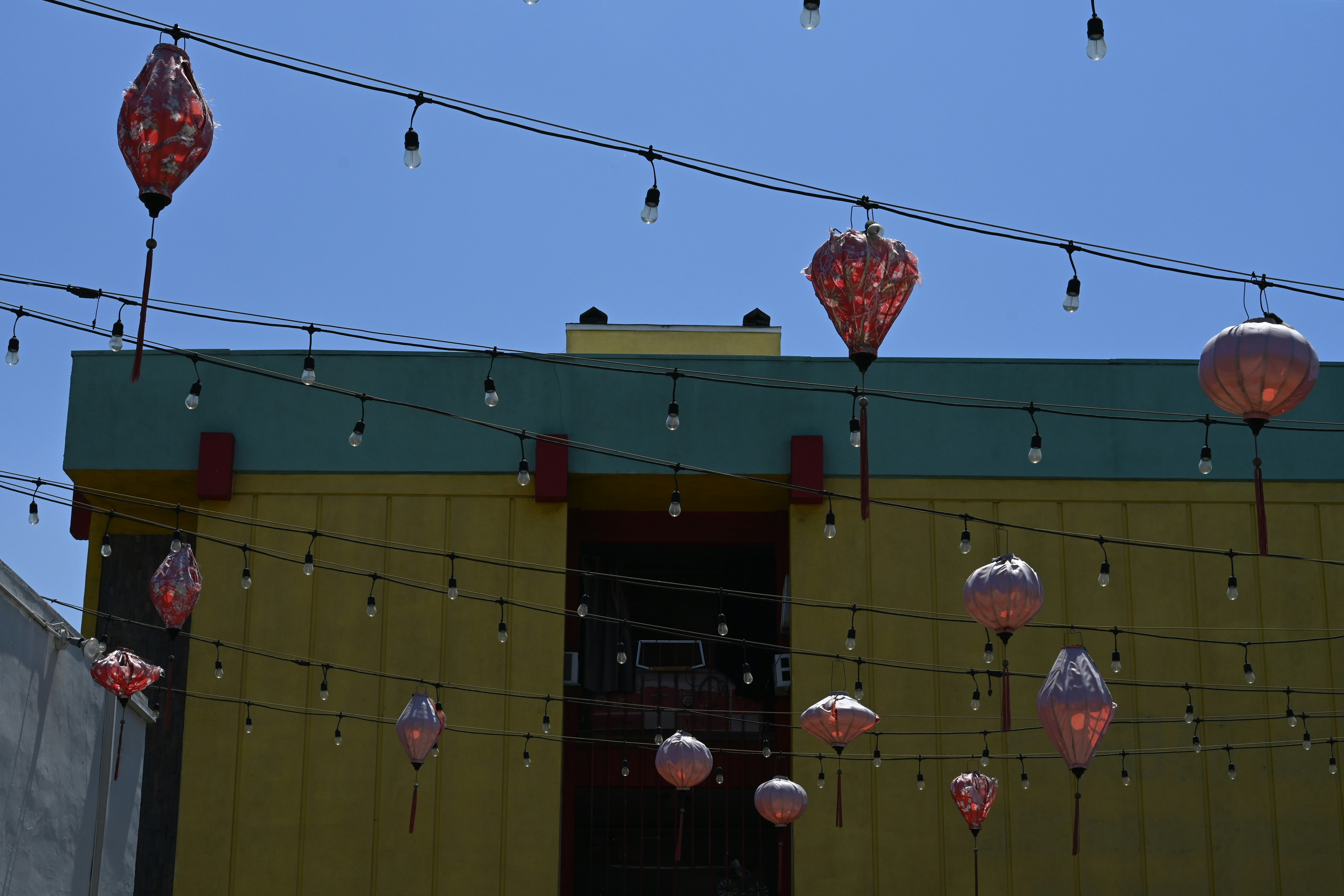 Floating Lanterns over a Yellow Facade