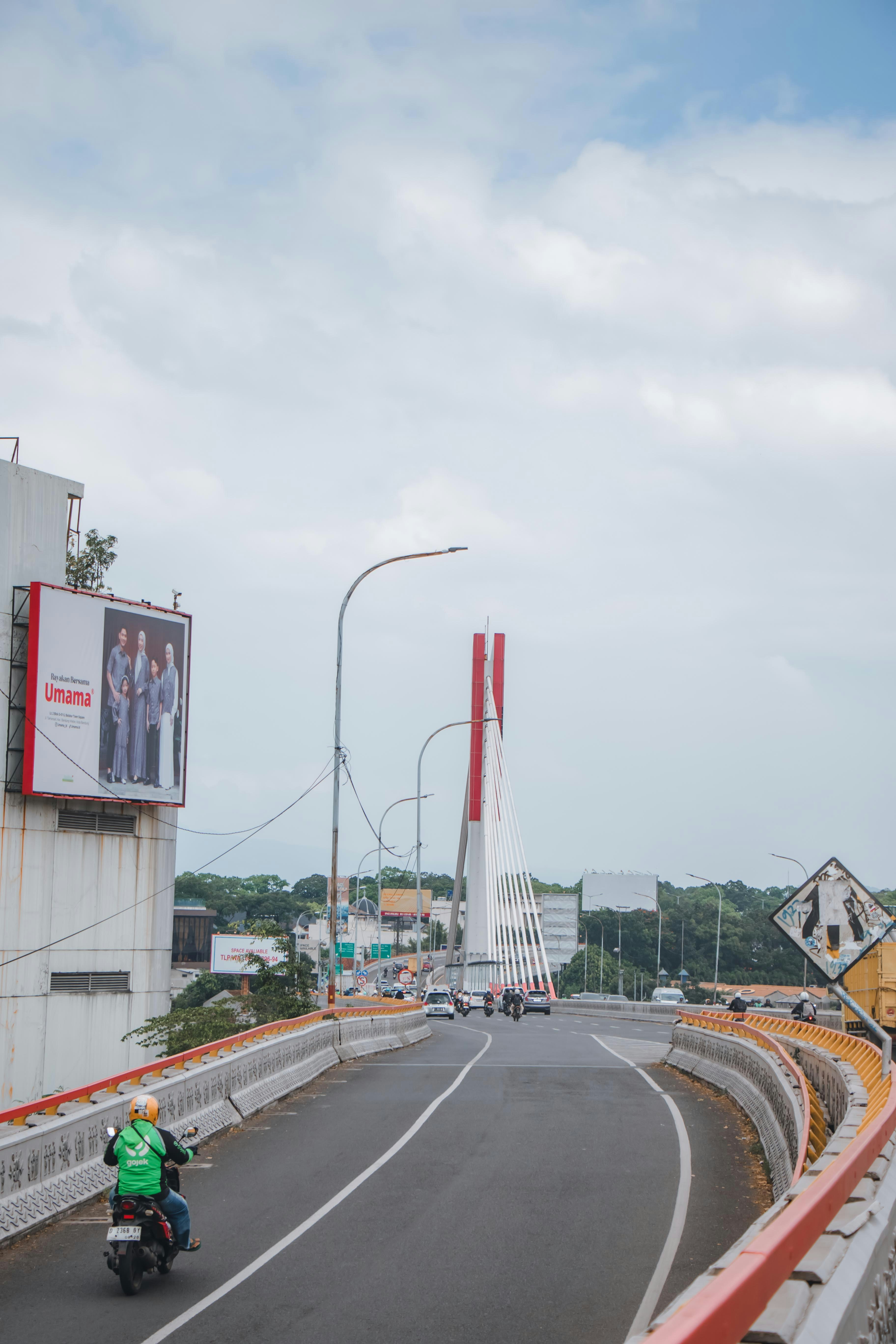 Bridge Approach: Rider in Green Navigates a Serene Wake