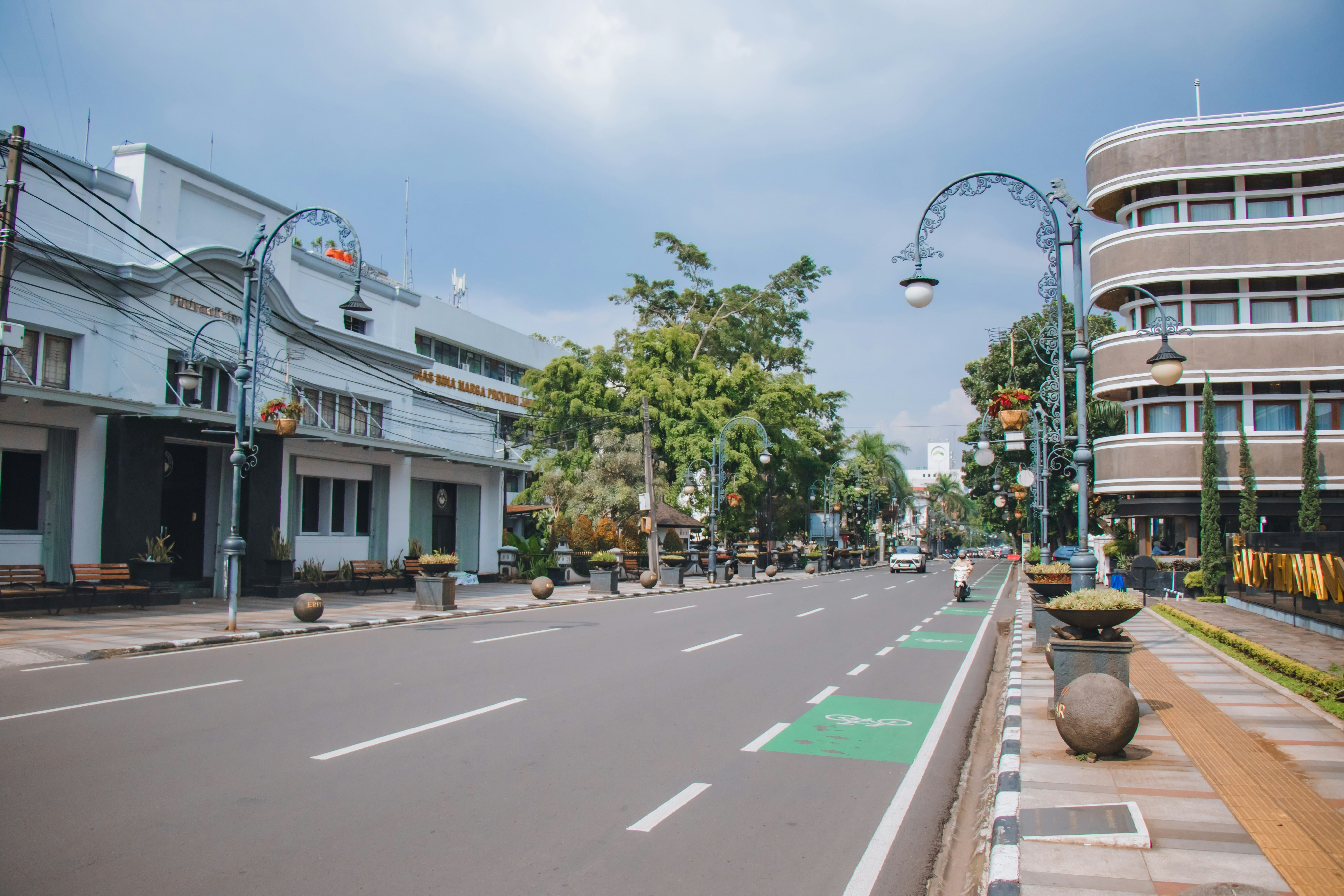 Street of Quiet Activity: A Sunny Boulevard with Stylized Street Lamps