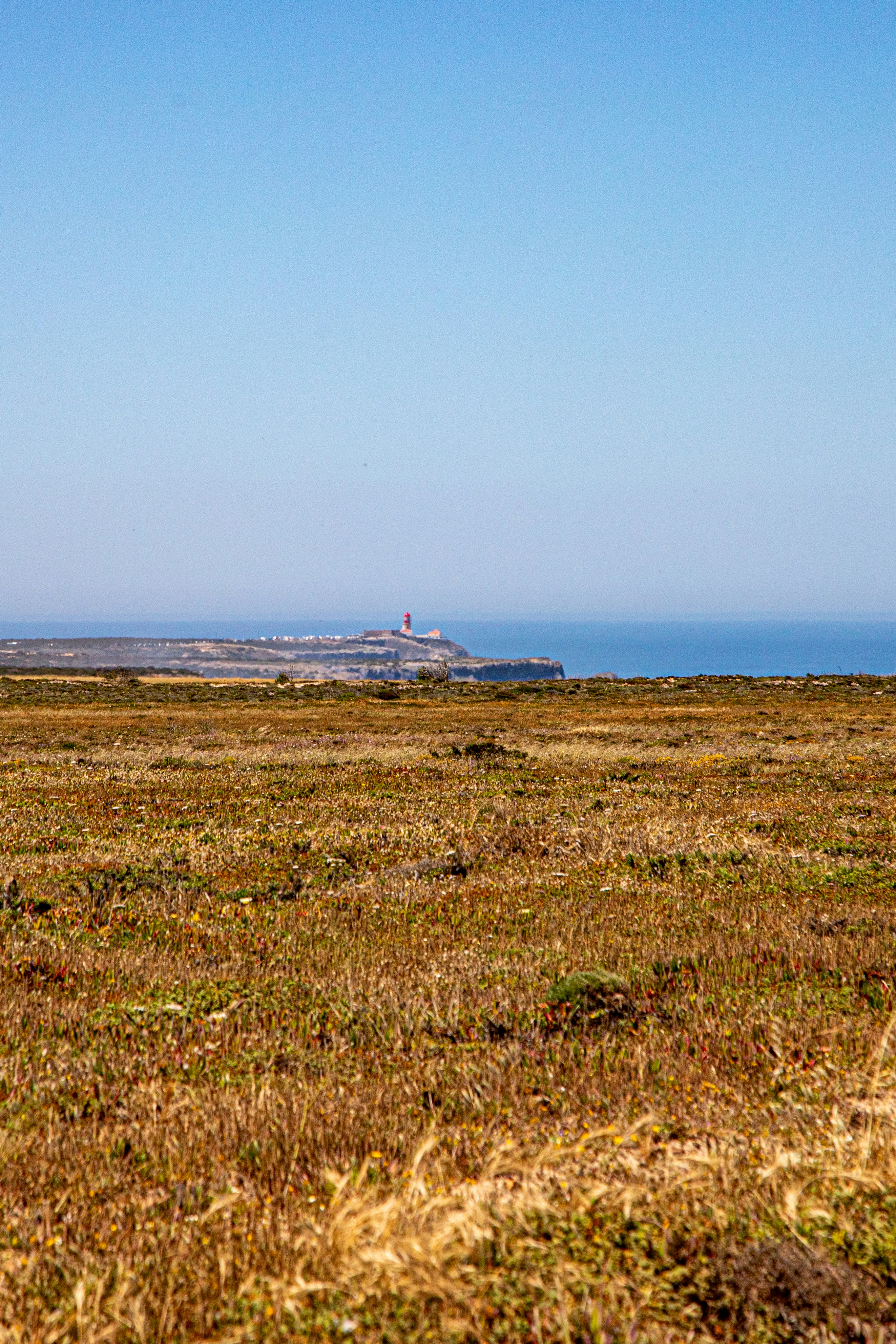 Coastal Horizon: Lone Lighthouse on the Distant Cape