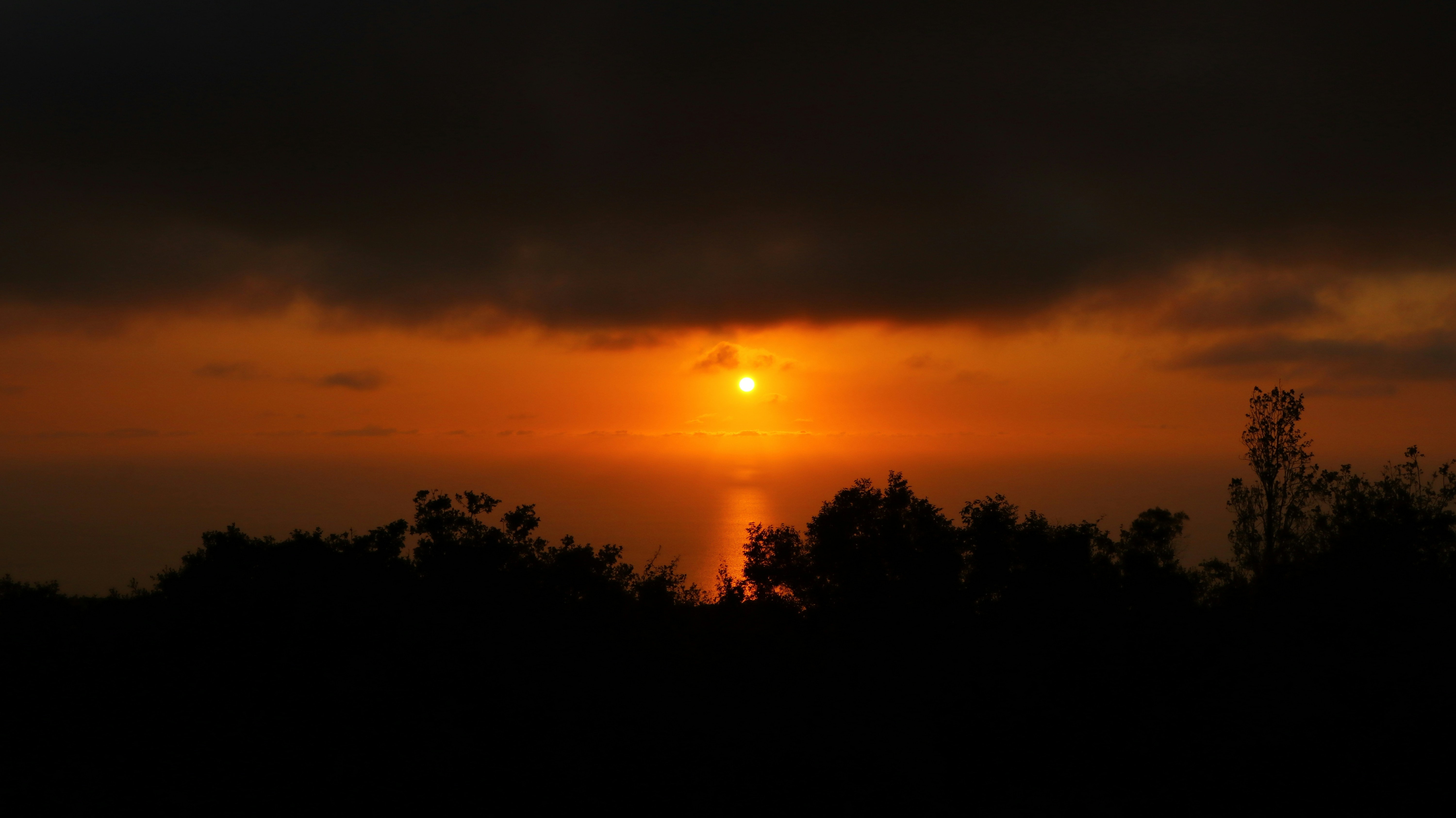 Sunset Collision: Central Orb Over Quiet Silhouette