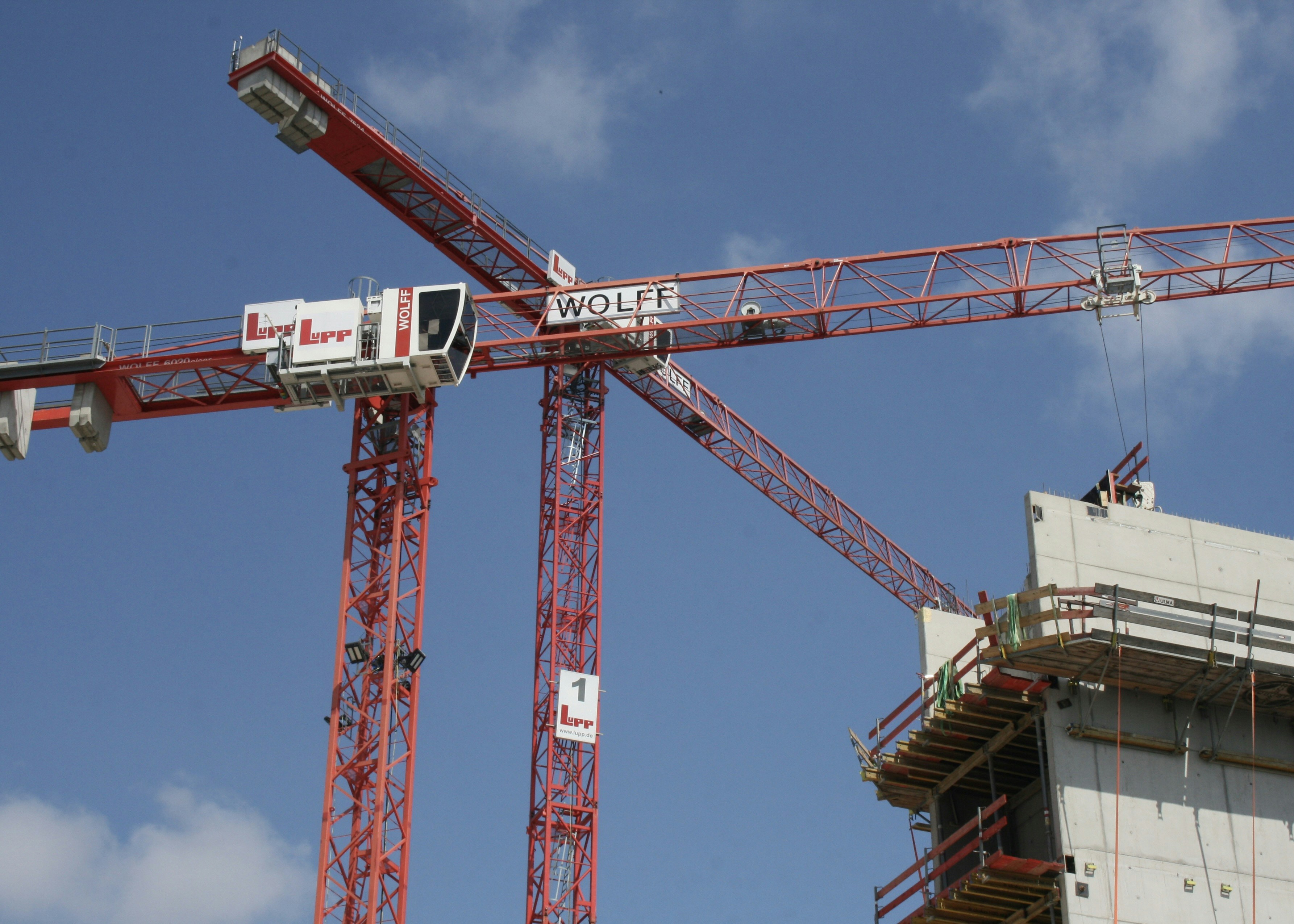 Towering Geometry: Cranes Reaching into a Clear Spring Sky