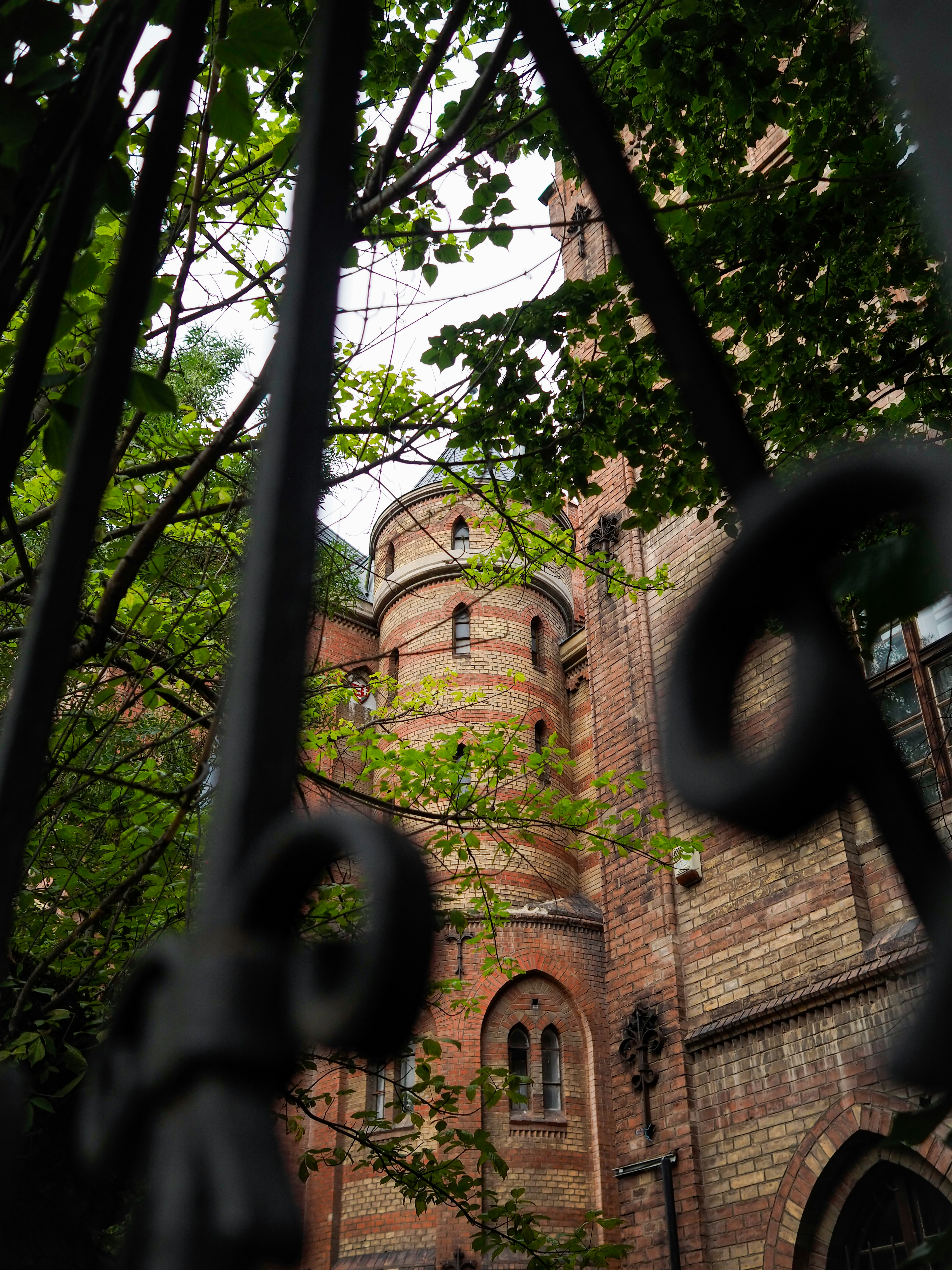 Overgrown Gable: Brick Turrets Framed by Wrought Iron