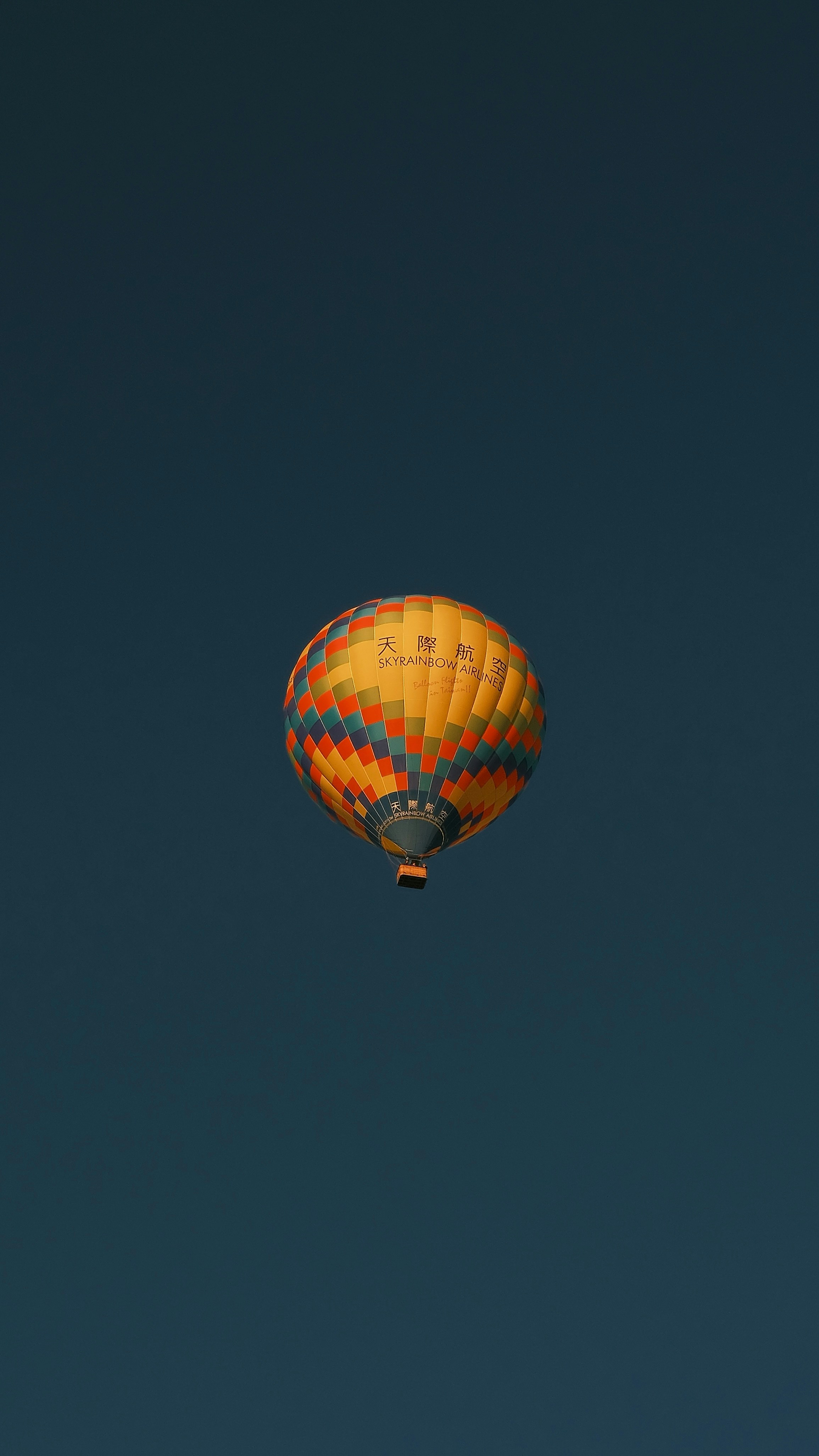 Floating Rainbow: A lone hot air balloon against a dusk-blue sky