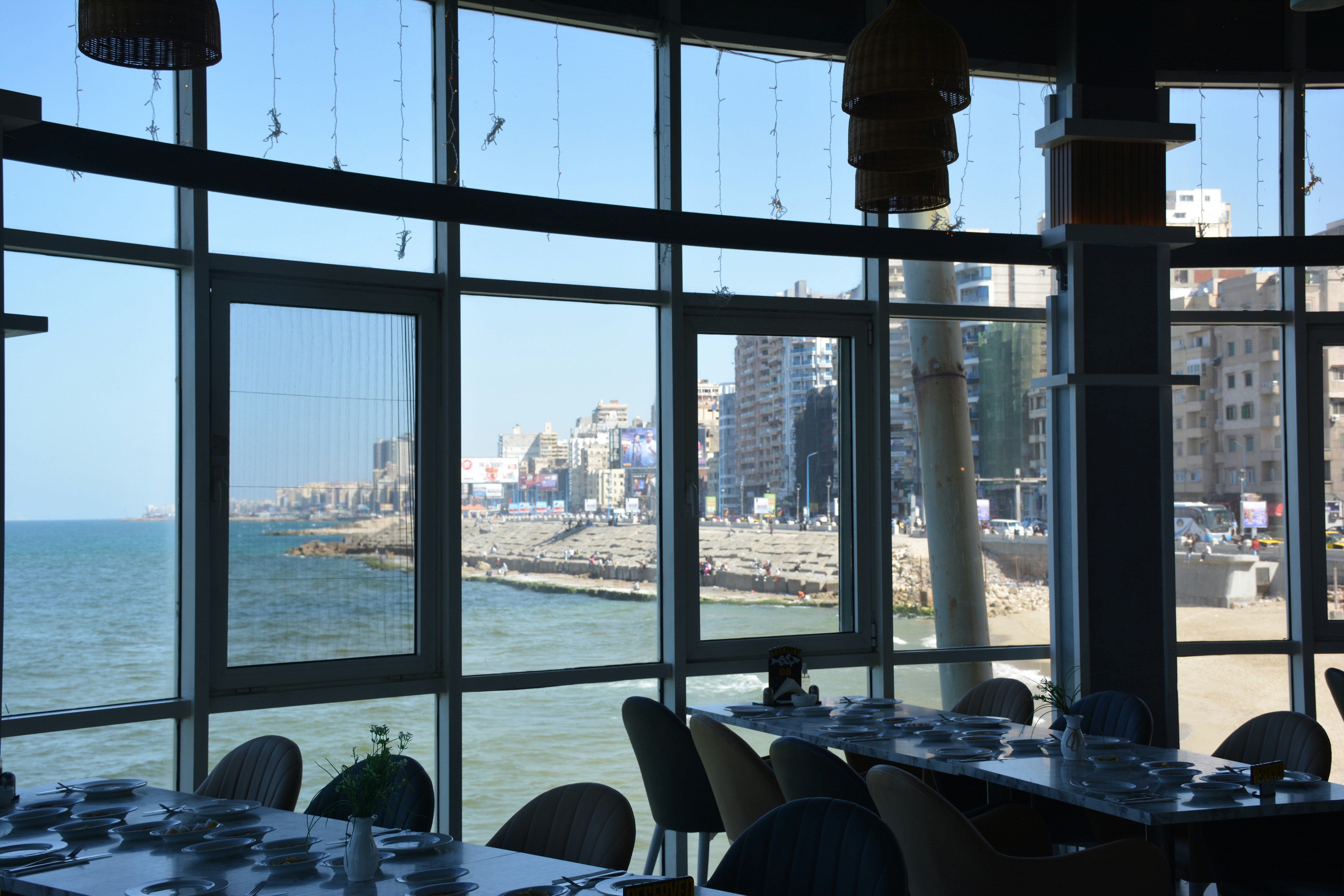Oceanfront Café Windows: Light, Shadow, and City Embrace