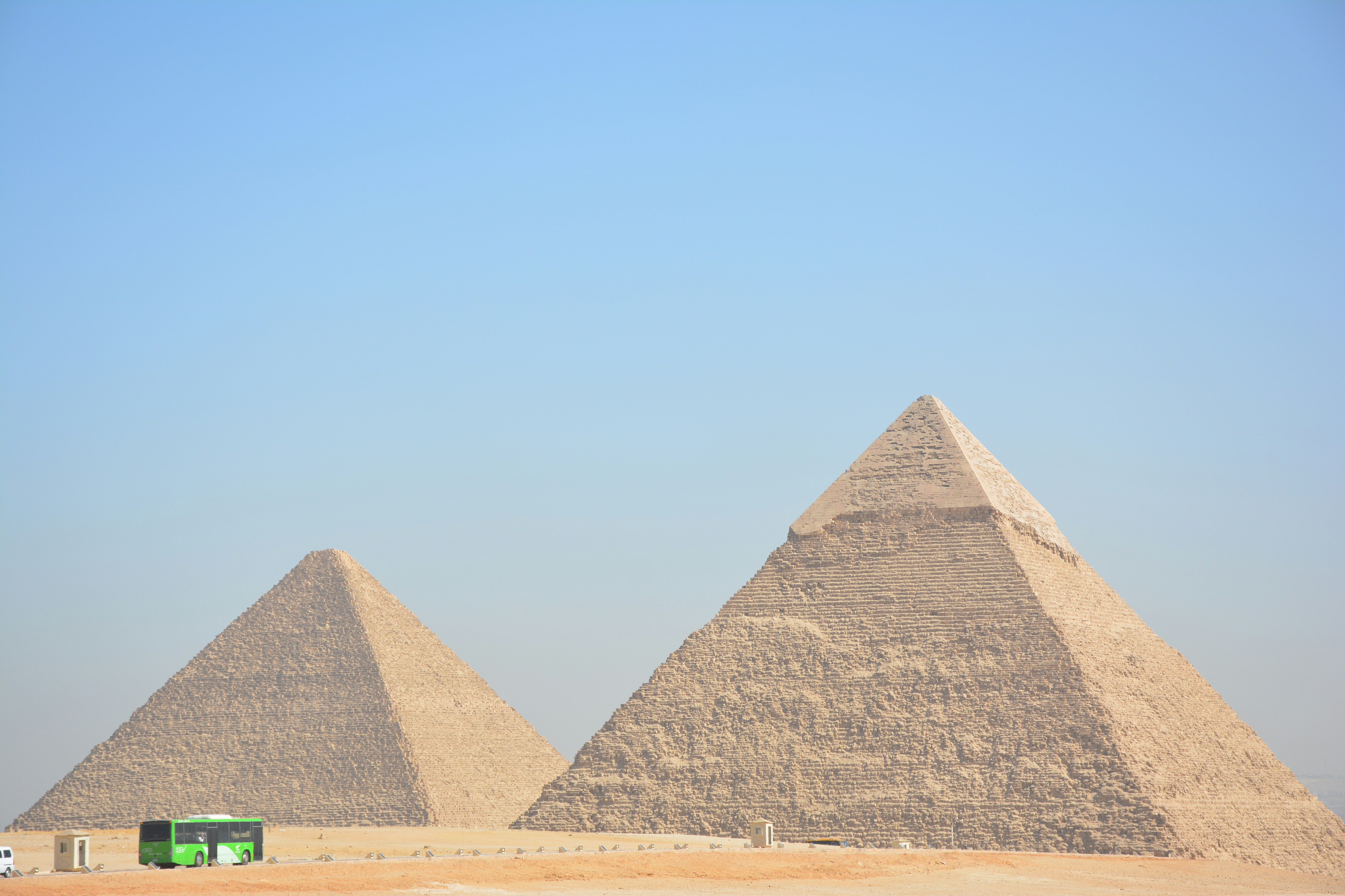 Sentries of the Desert: The Pyramids Rising Under Clear Sky