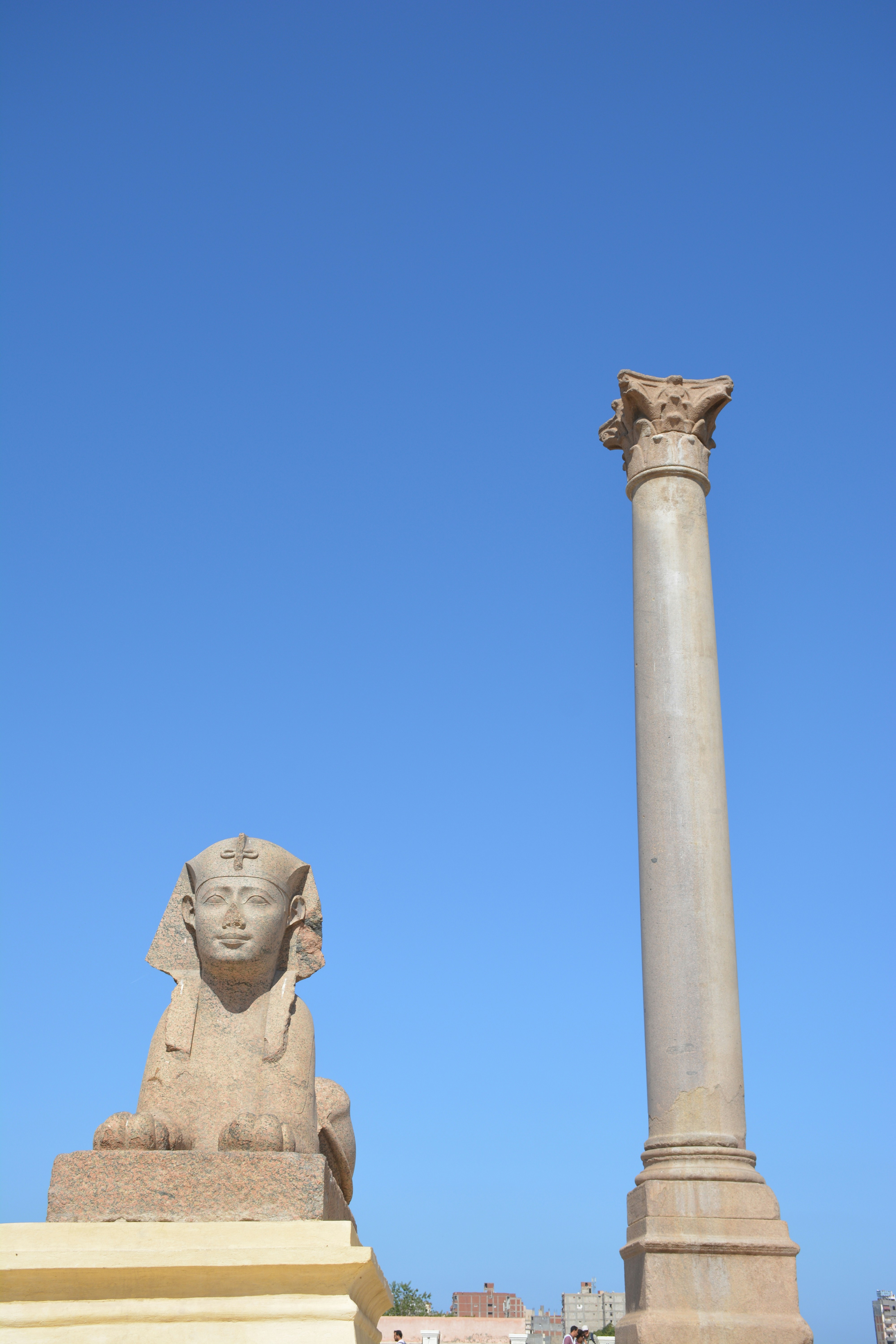 Ancient sphinx statue and roman column against a blue sky. photo – Free ...