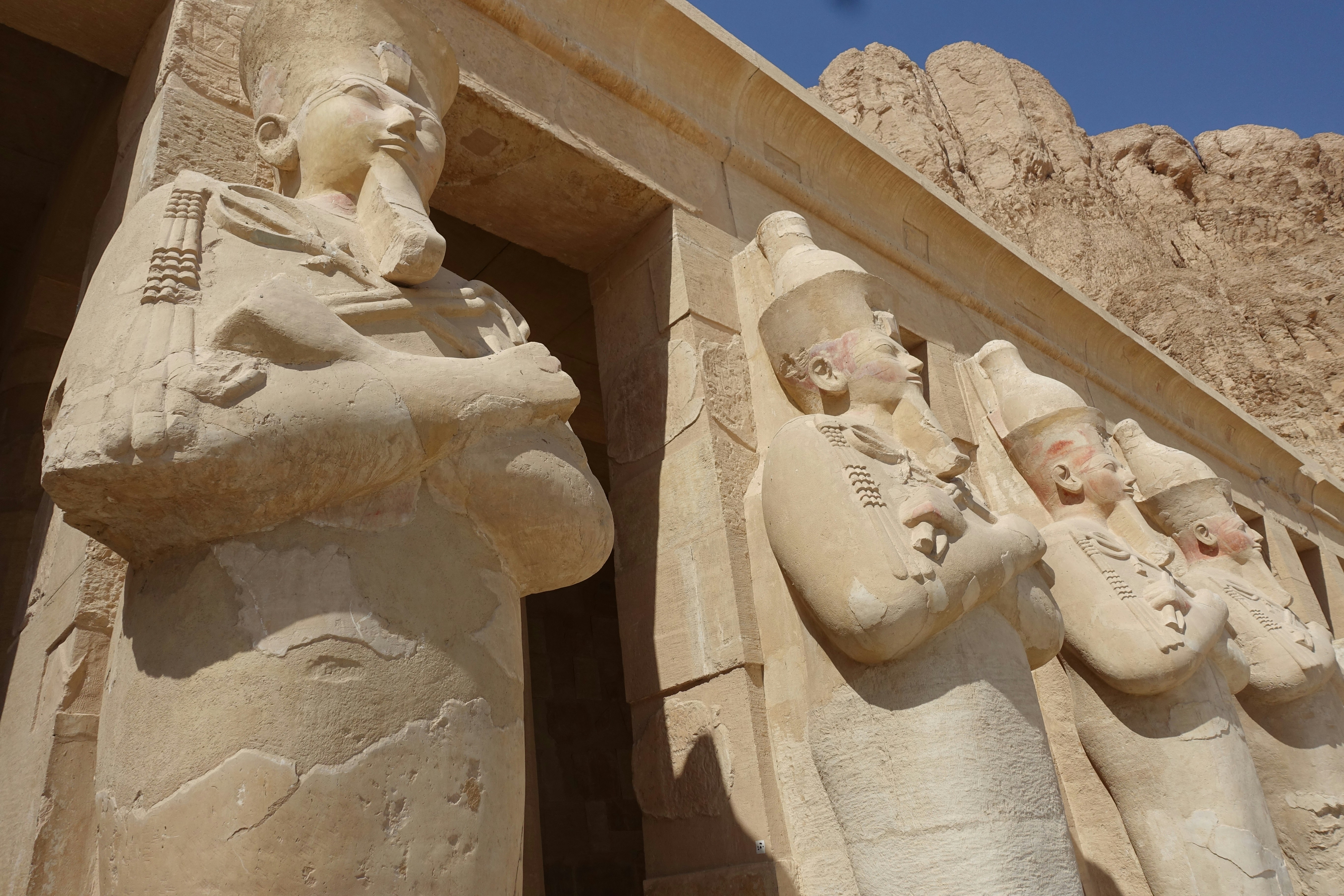 Stone guardians in a sunlit frieze: Muted shadows and colossal forms