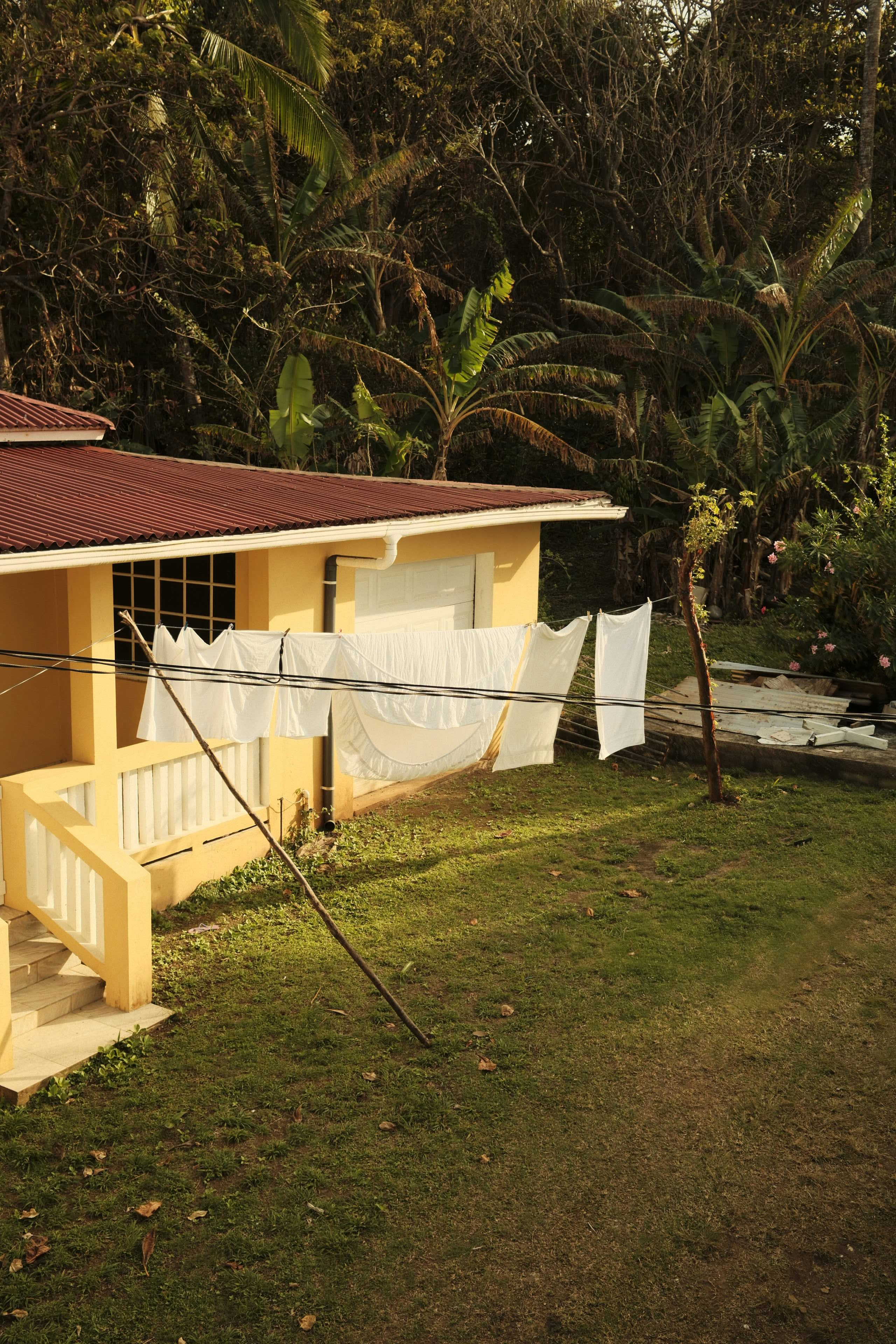 Sunlit Laundry Line Draped Across a Yellow House