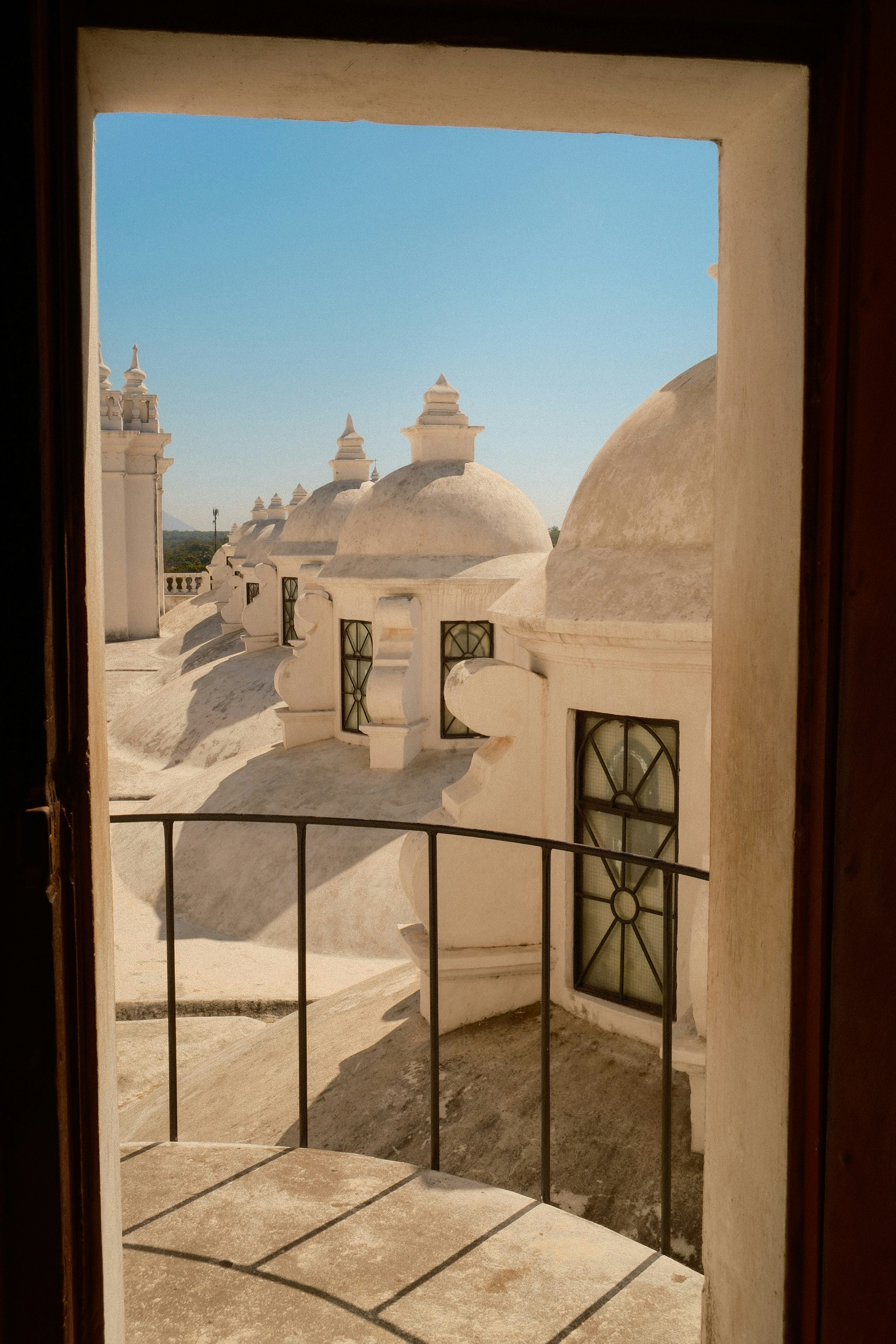 White domes and clear blue sky through an archway.