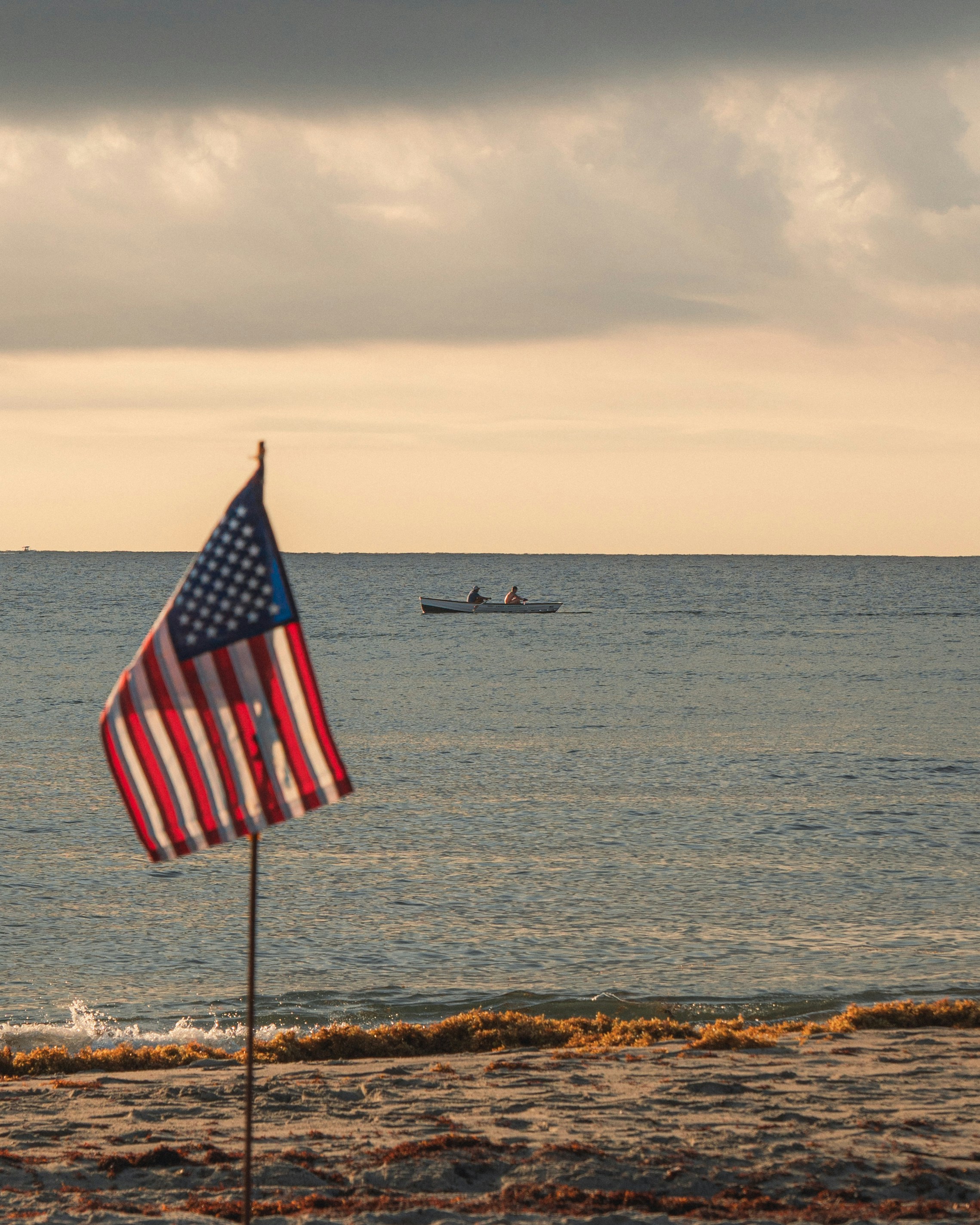 Flag at the Shore: Quiet Horizon and Distant Boat