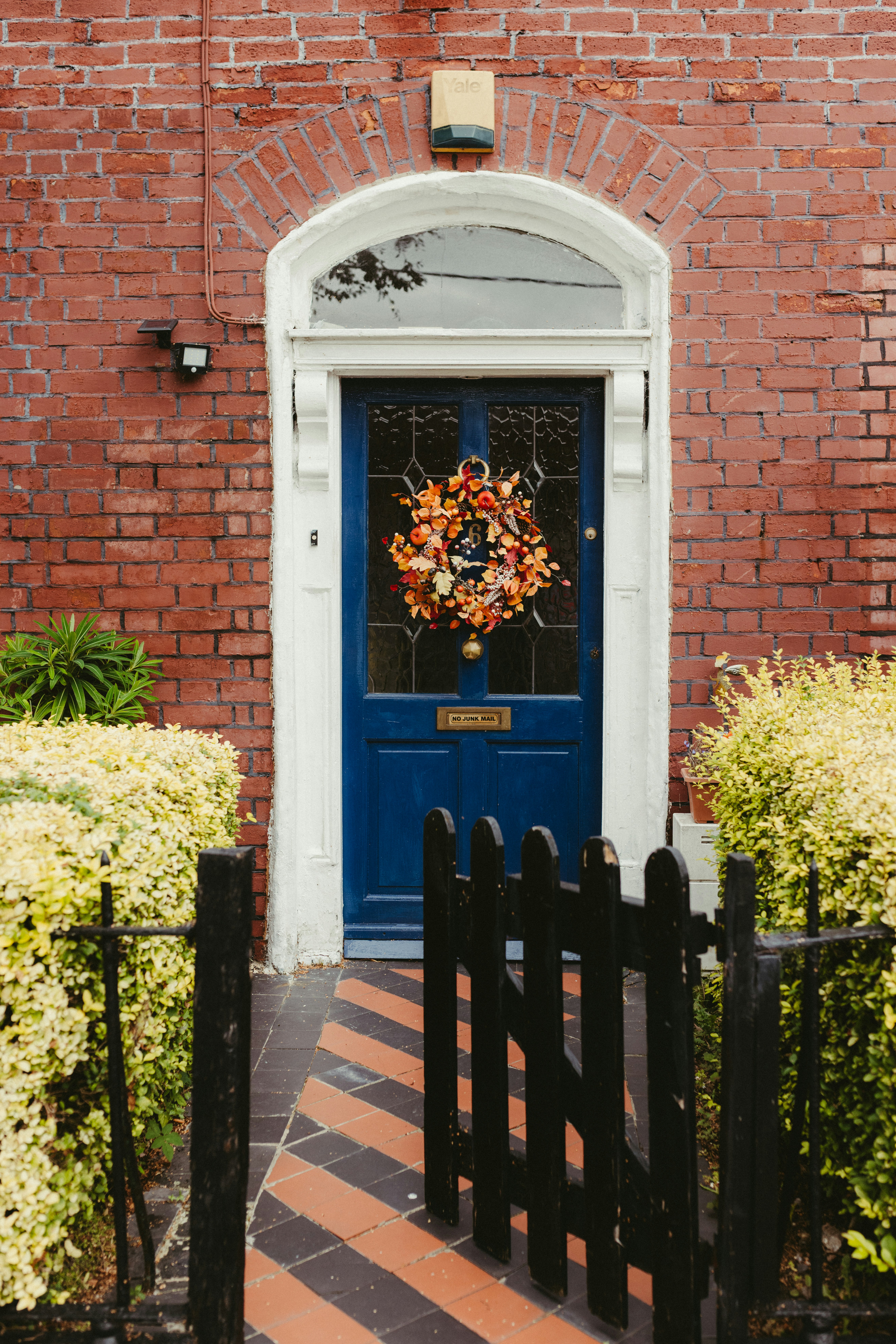 Blue Door with Autumn Wreath: A Welcoming Brick Facade