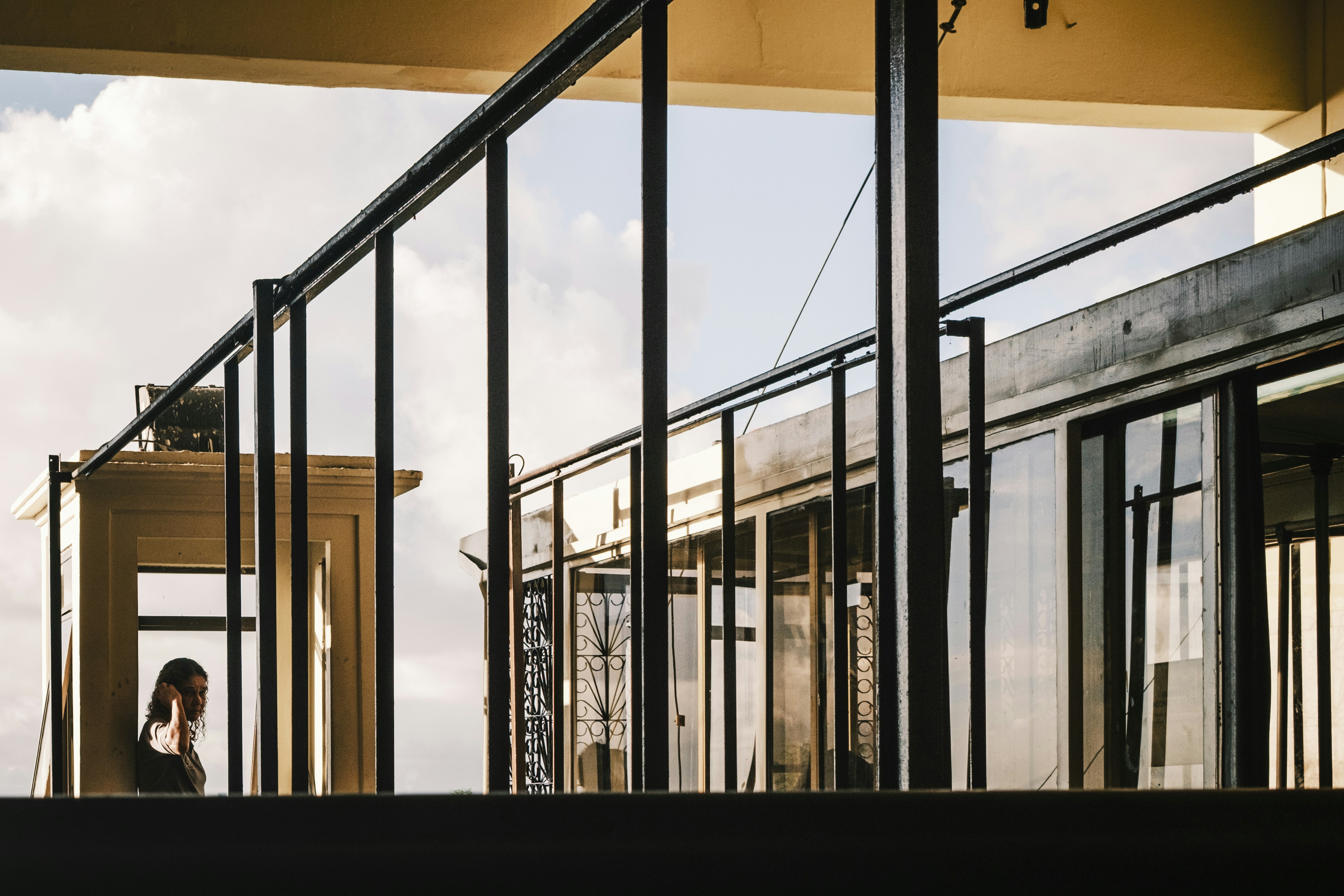 Silhouette at the Balustrade: A Quiet Moment in Fractured Light