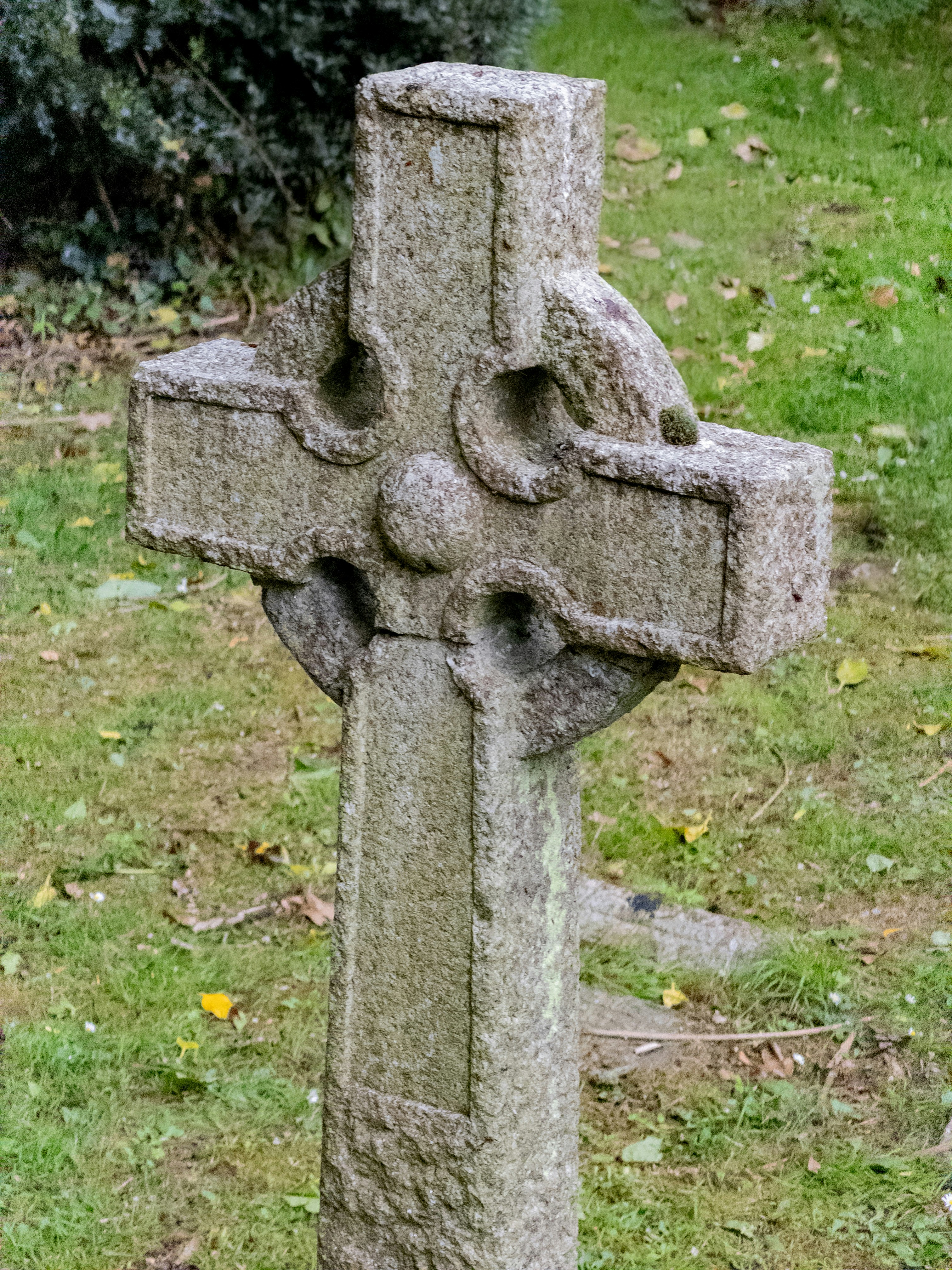 A weathered cross rising in a quiet graveyard