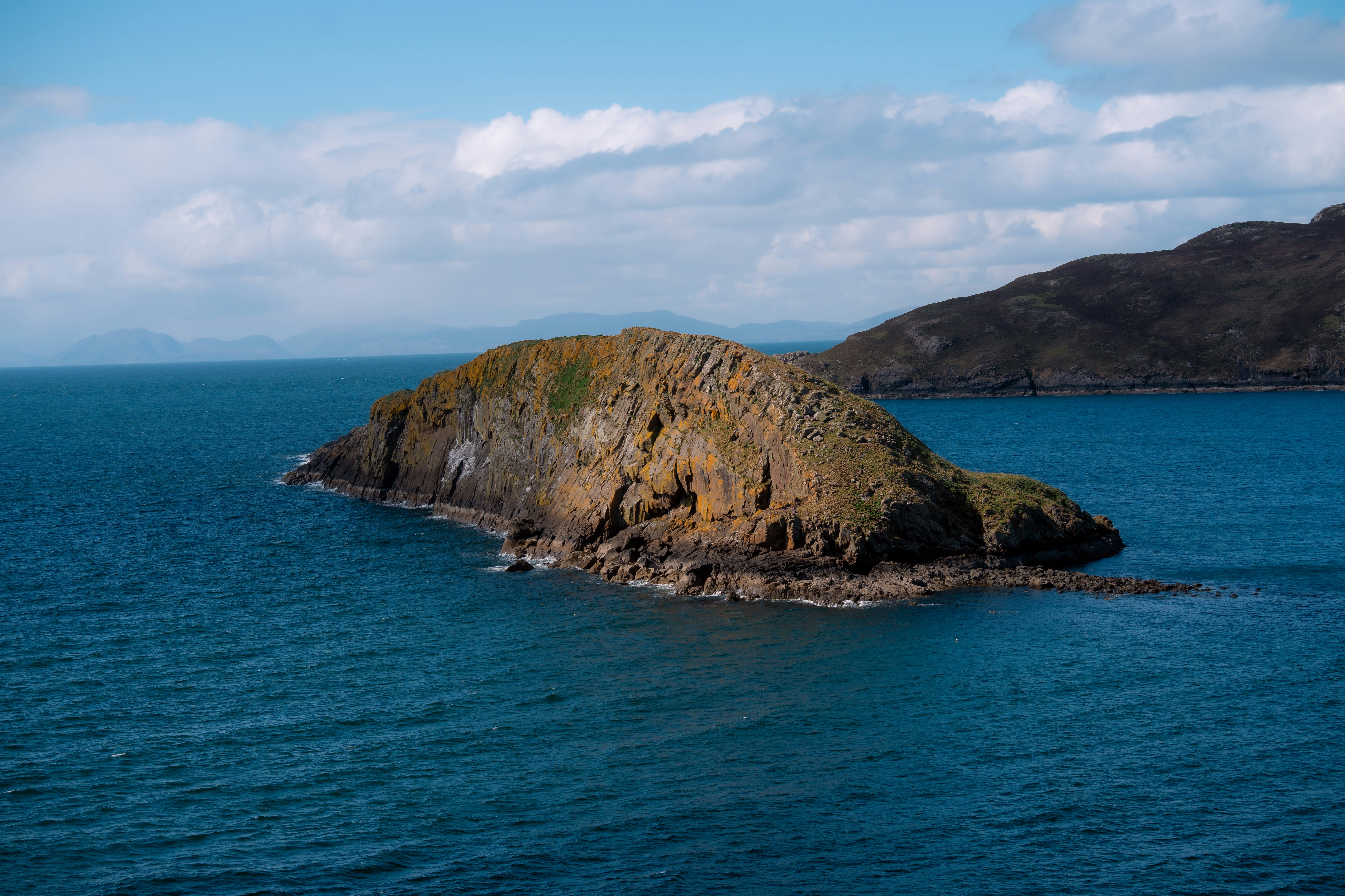 Rock Outcrop in Azure Calm: A Coastal Islet Emerges from the Sea