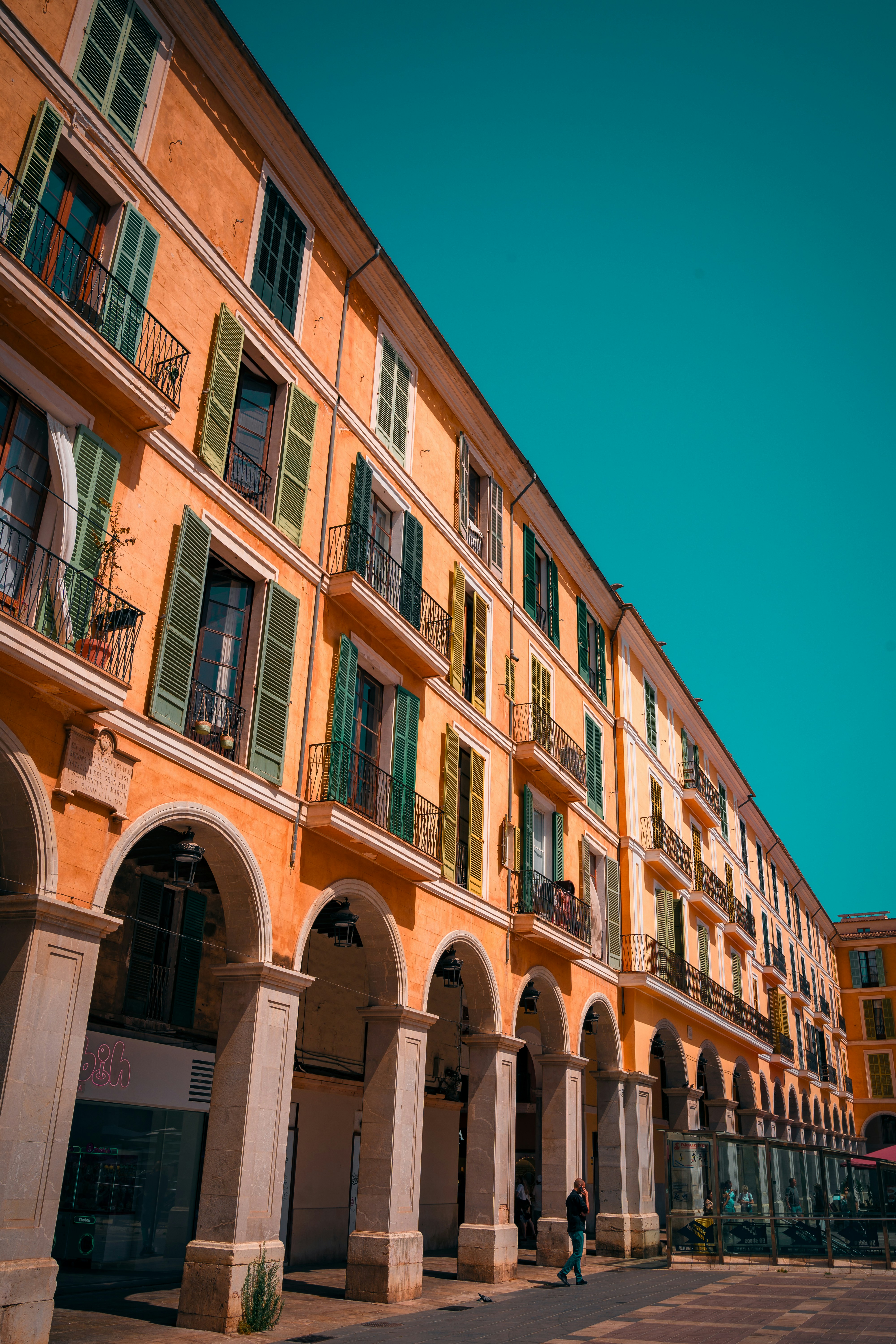 Sunlit Arcade: A Colorful European Façade with Shaded Archways