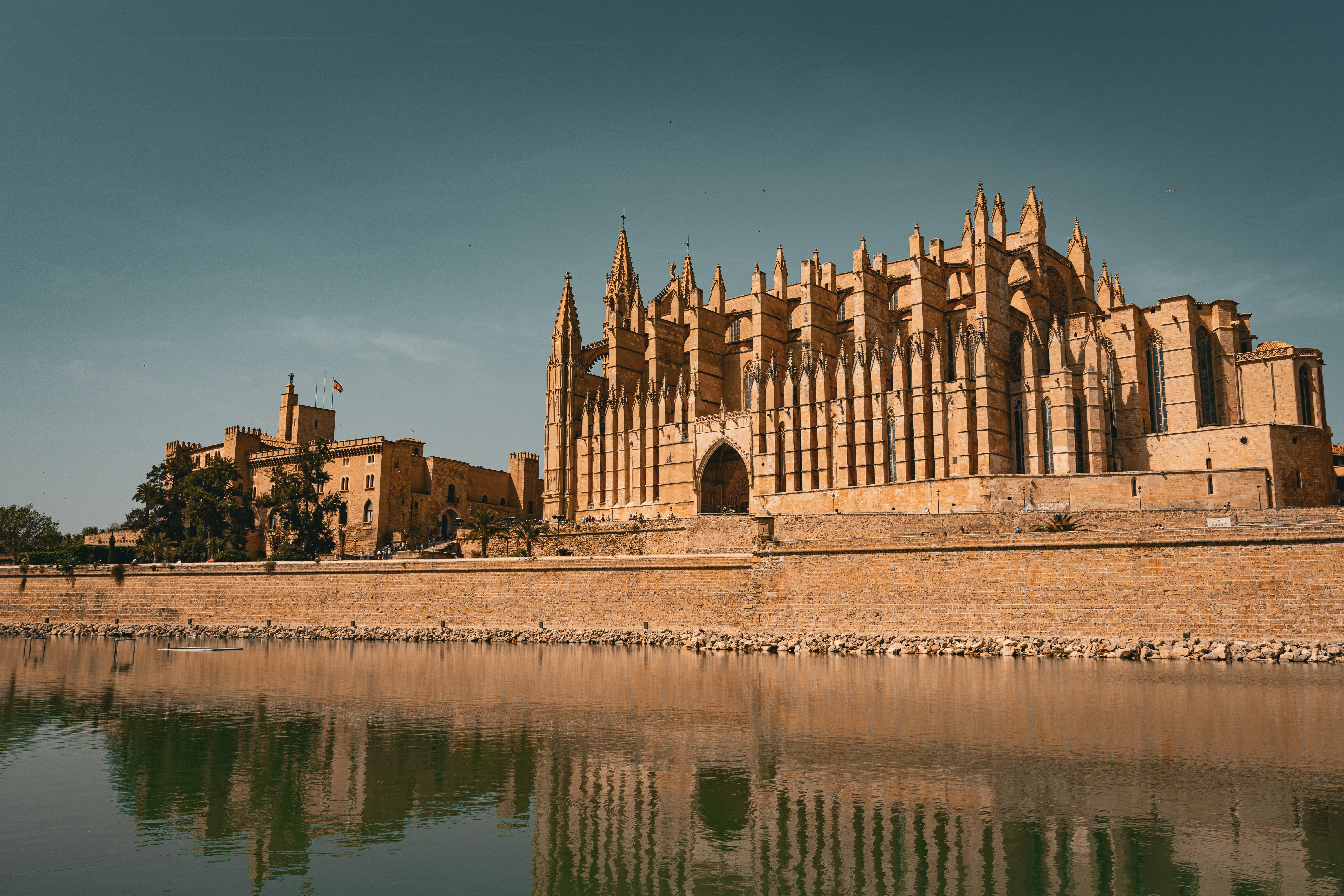 Stone Cathedral by the River: A Sunlit Fortress Framed in Glassy Waters