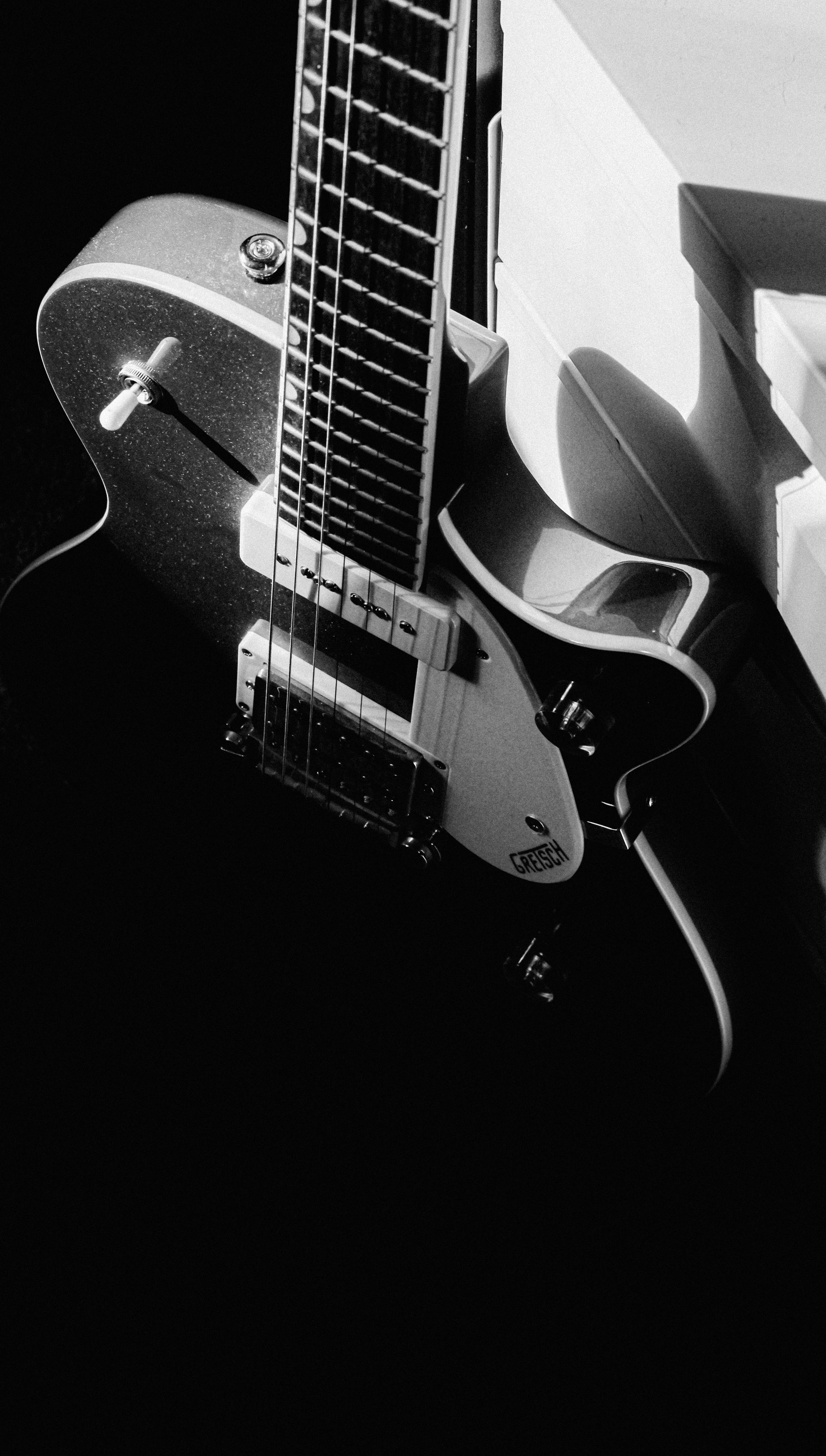 Monochrome Resonance: A Cornered Guitar in Shadowed Light