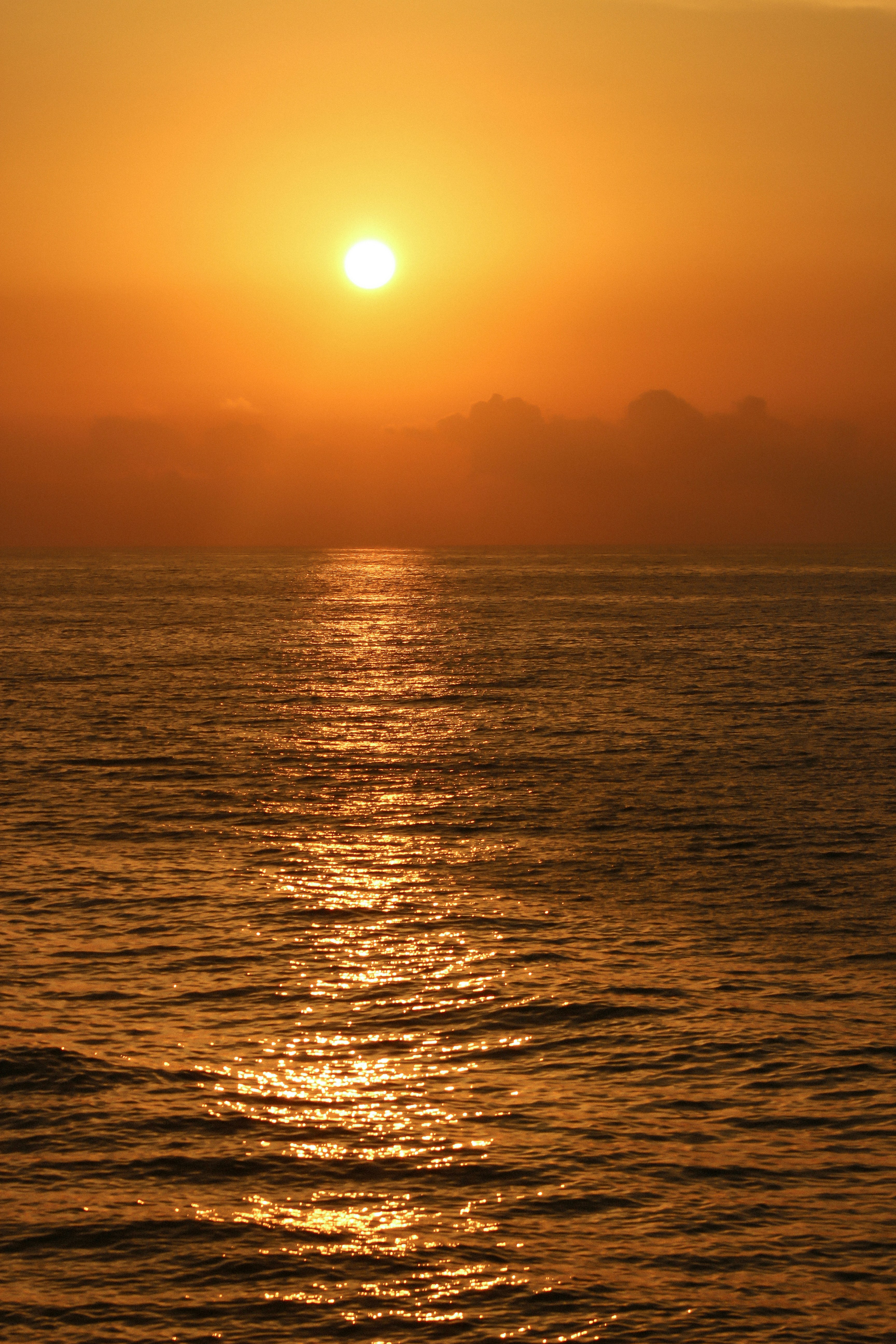 Glowing Horizon: Sun over a Serene Sea at Dusk