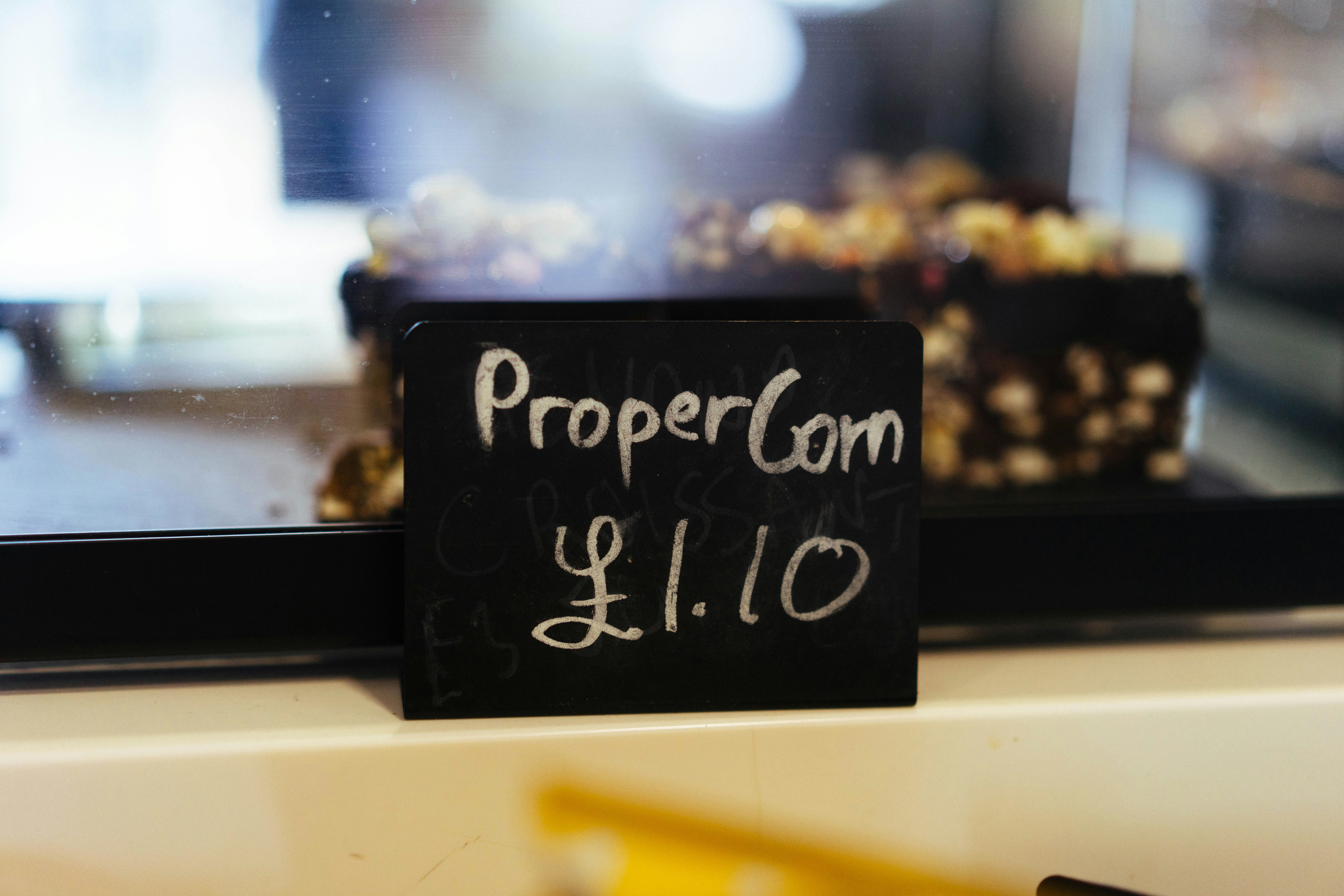 Chalkboard Sign Beneath the Pastry Display at the Café Counter