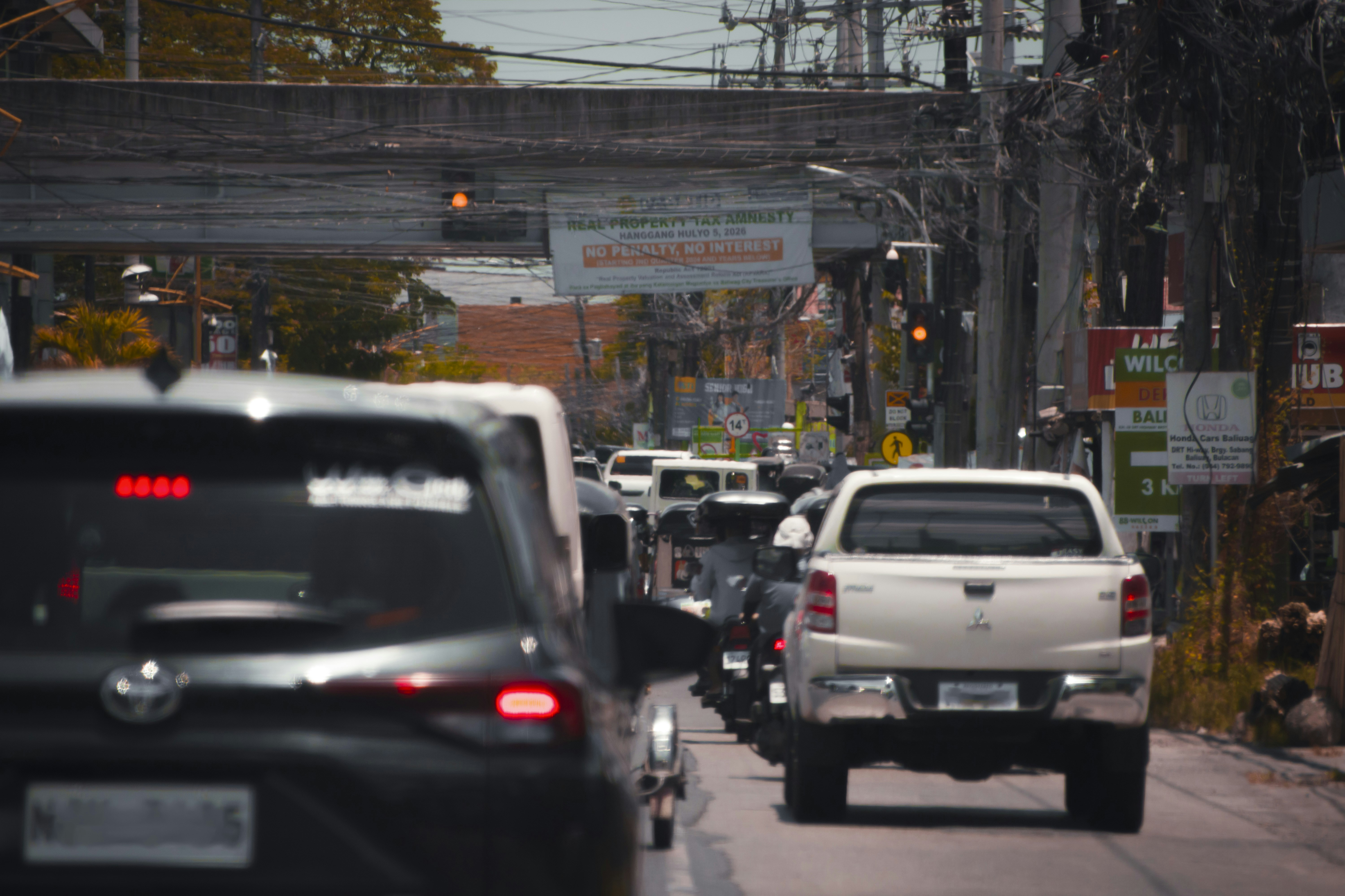 Rush Hour in a Narrow Street: A White Pickup Leads the Way