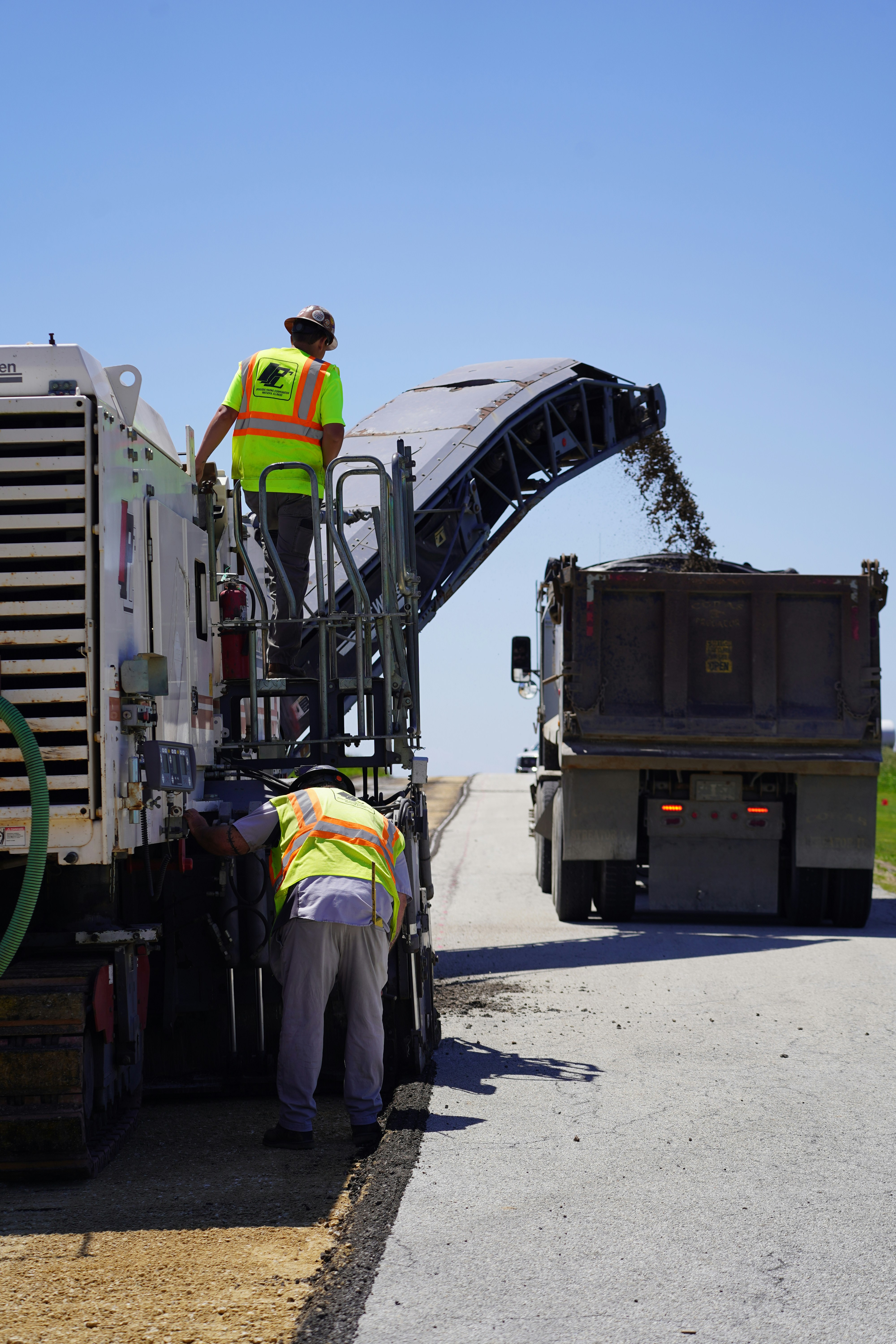 Crew at Work: Asphalt Paving in Bright Midday Light