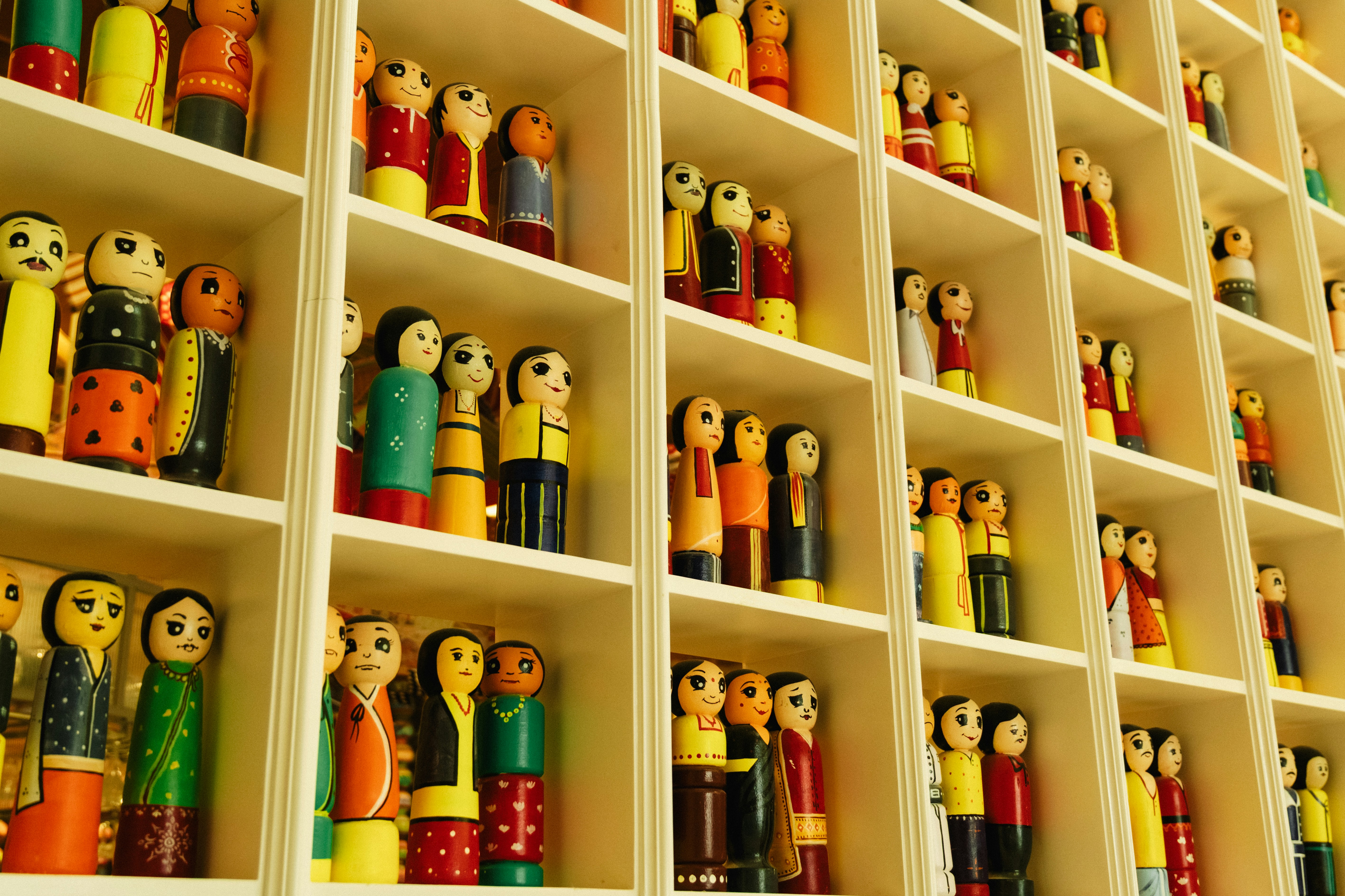Rows of colorful wooden nesting dolls on sunlit shelves