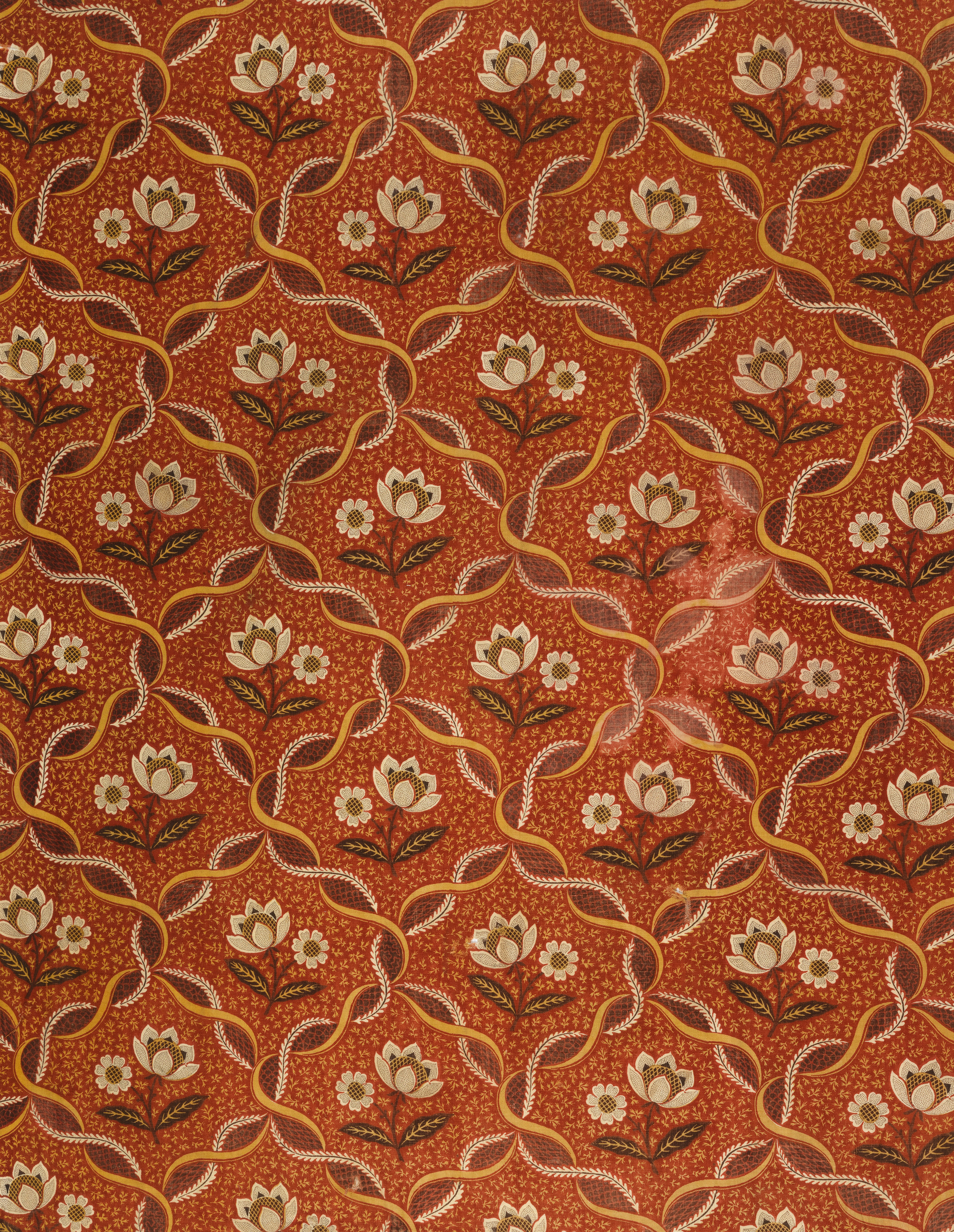 Textile. Description Diamond lattice enclosing floral sprigs in red, yellow and white. This is a very good copy of a Jouy design. On the Jouy fabric the floral veins are in lines; here they are scattered dots. Record ID chndm_1985-6-1