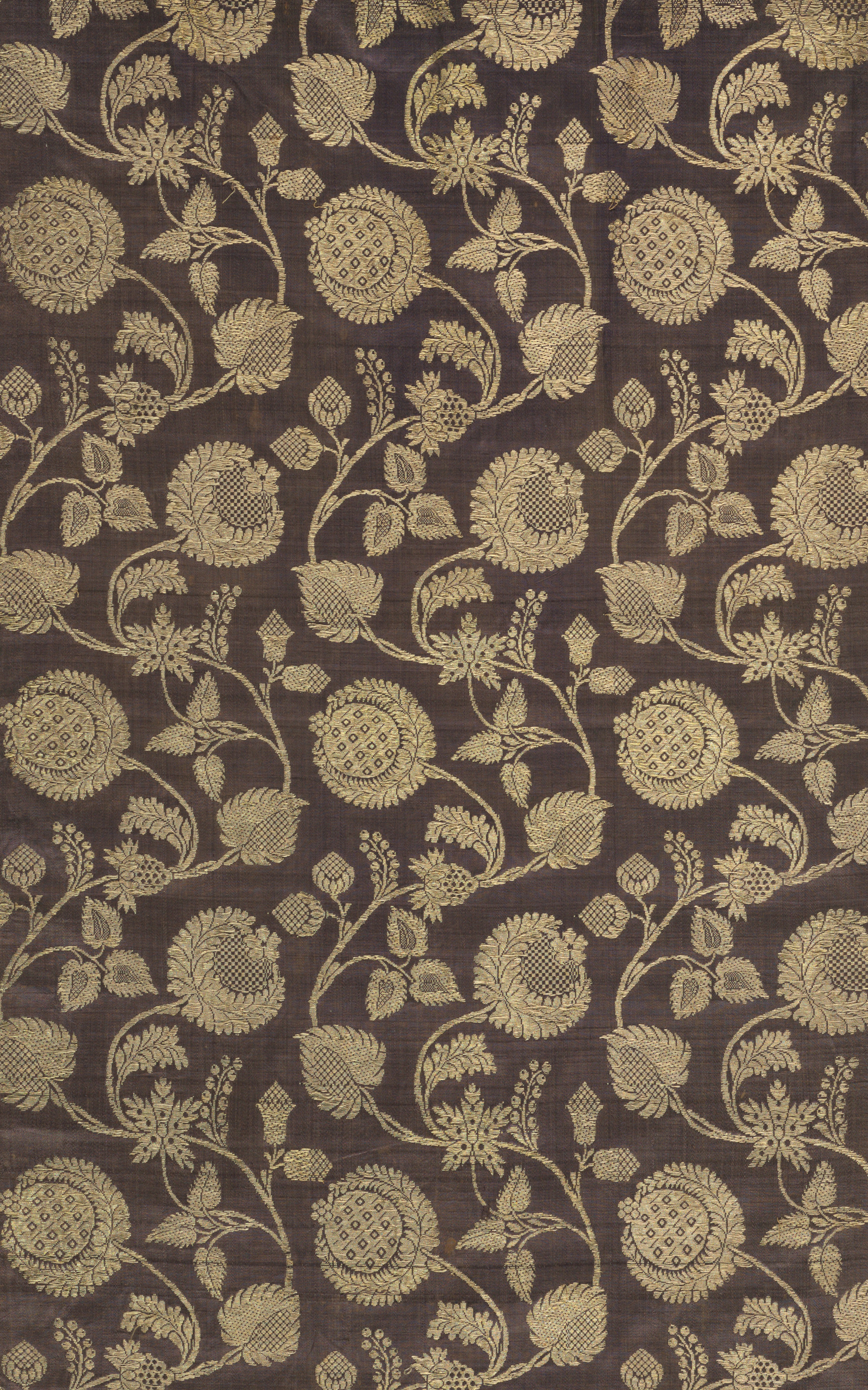 Textile. Description Dark purple satin ground with closely-spaced serpentines of slender branches with large conventionalized flowers, fruit, and foliage brocaded in gold metallic thread. Date 19th century. Record ID chndm_1913-13-3