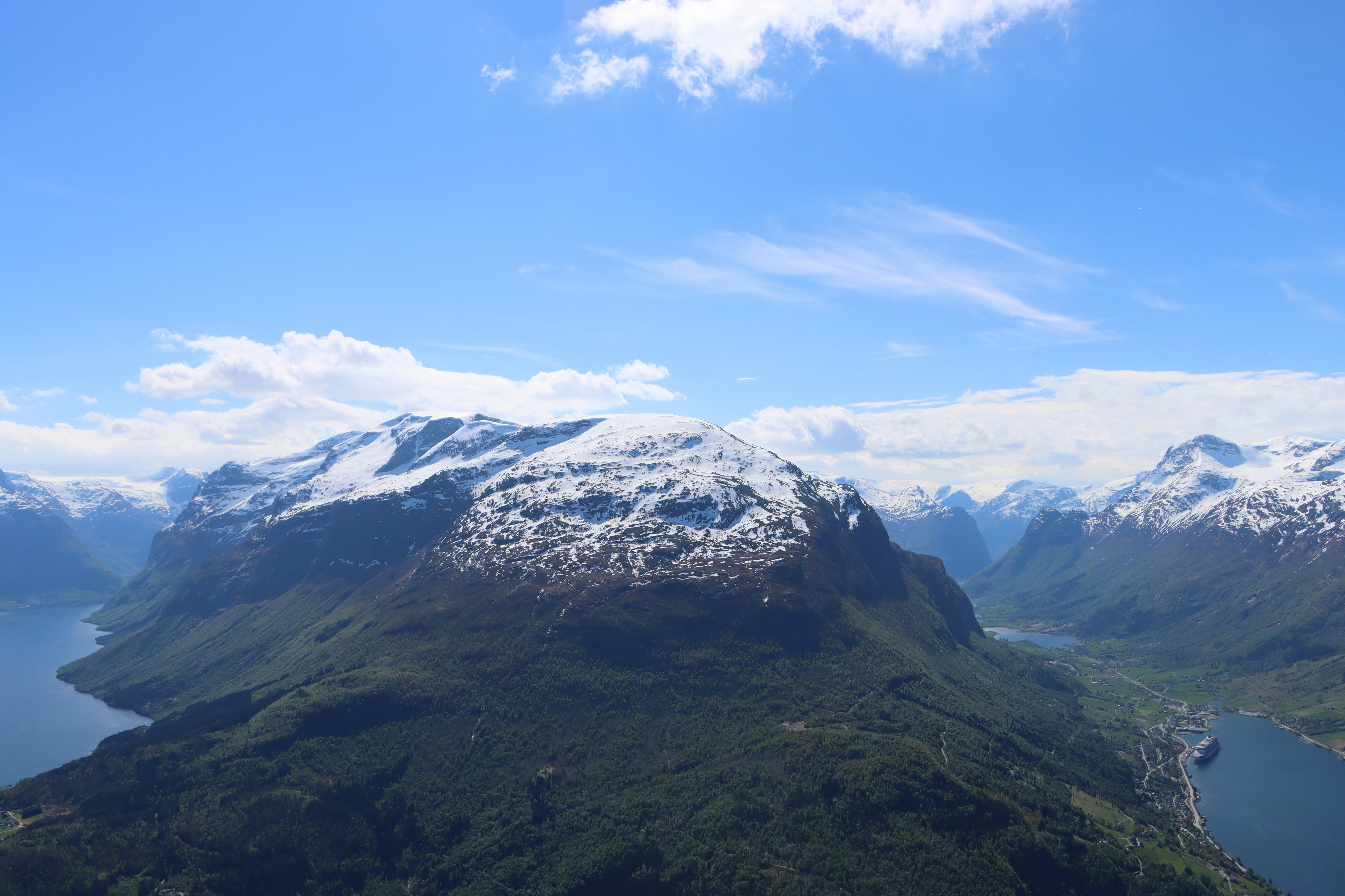 Snow-Capped Peak Looms Over Fjord-Ringed Landscape from Aerial Perspective