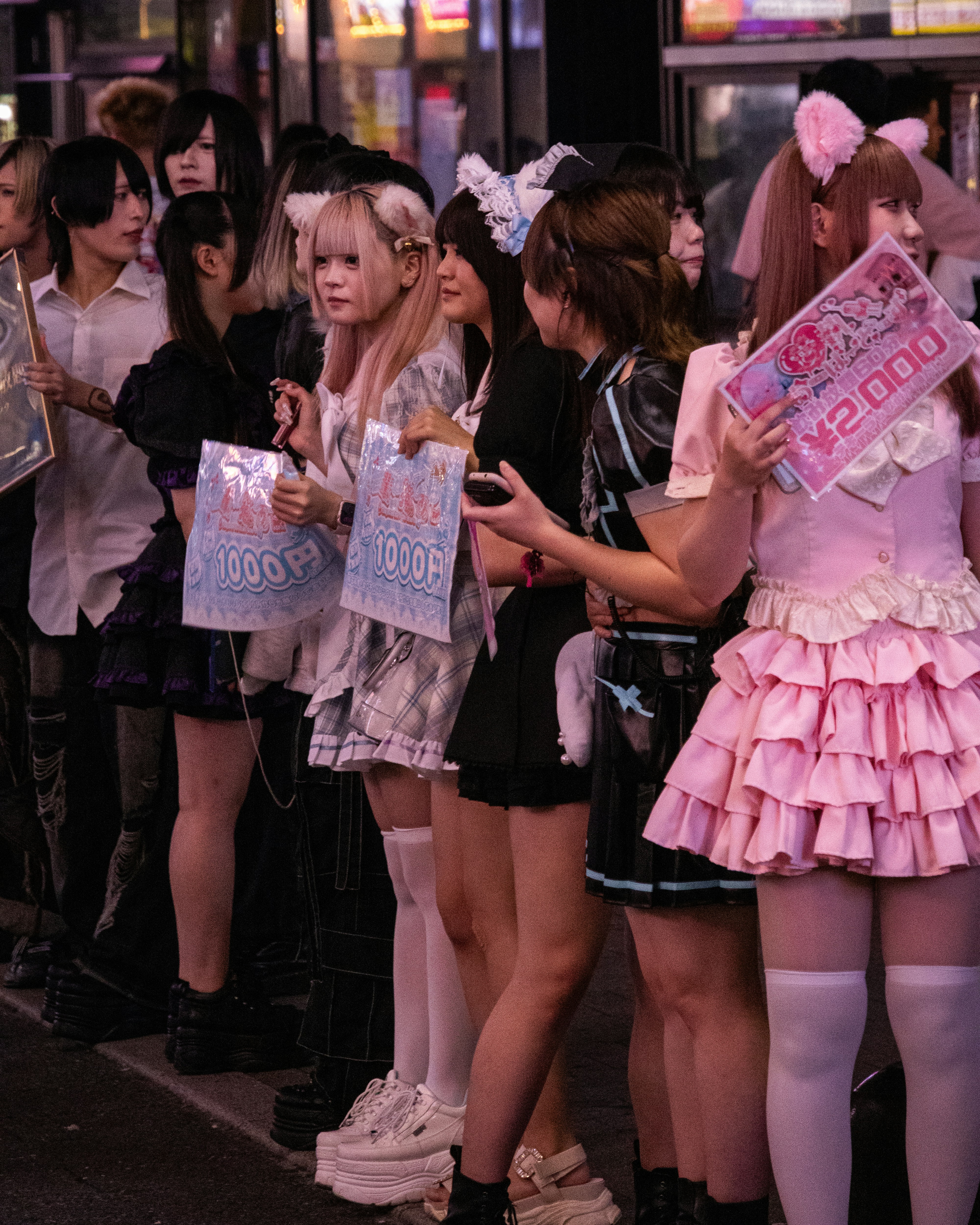 Cosplay queue under neon glow: a line of detailed costumes and pastel hues