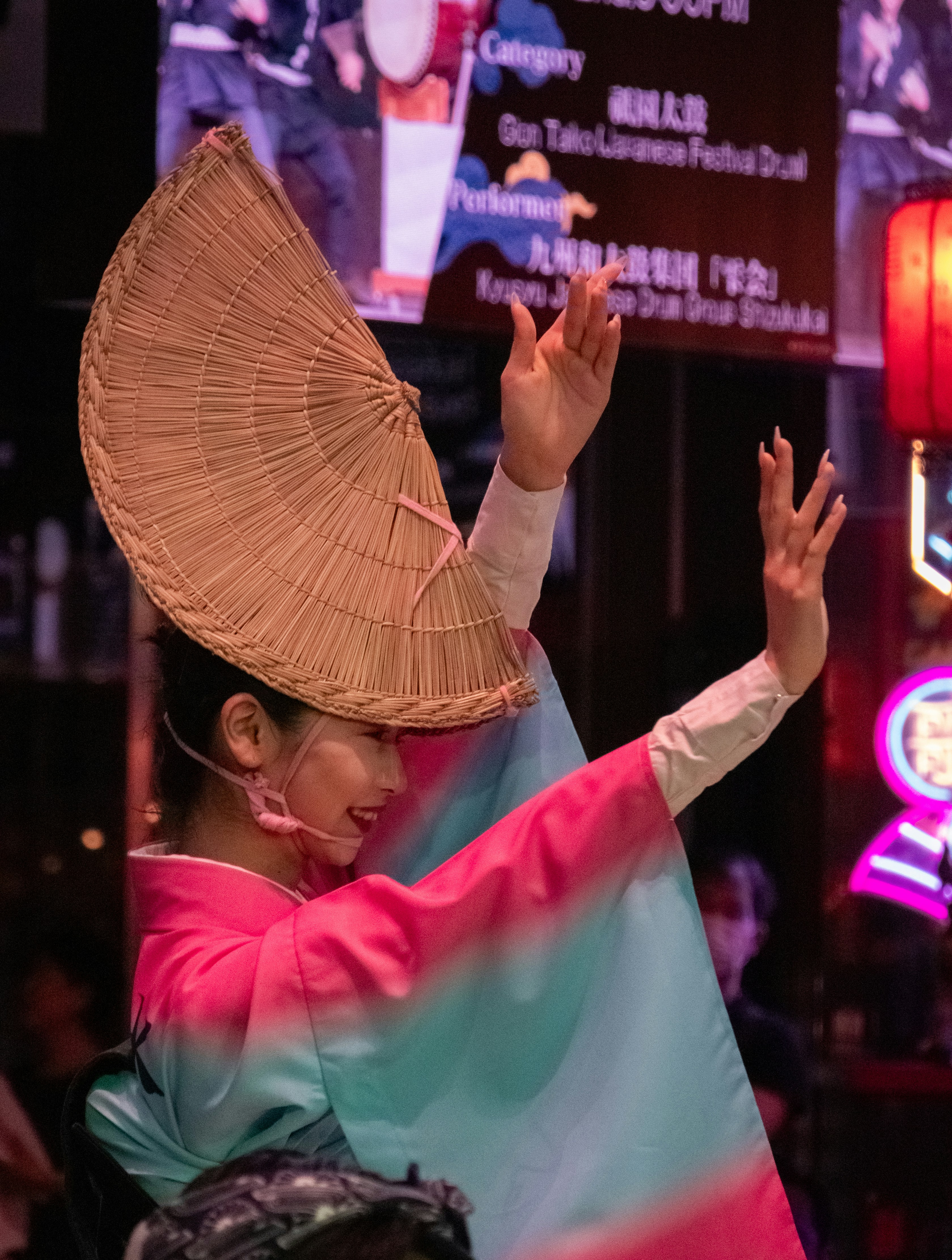 Silk in Motion: A Dancer’s Hat and Graceful Hand at the Night Market