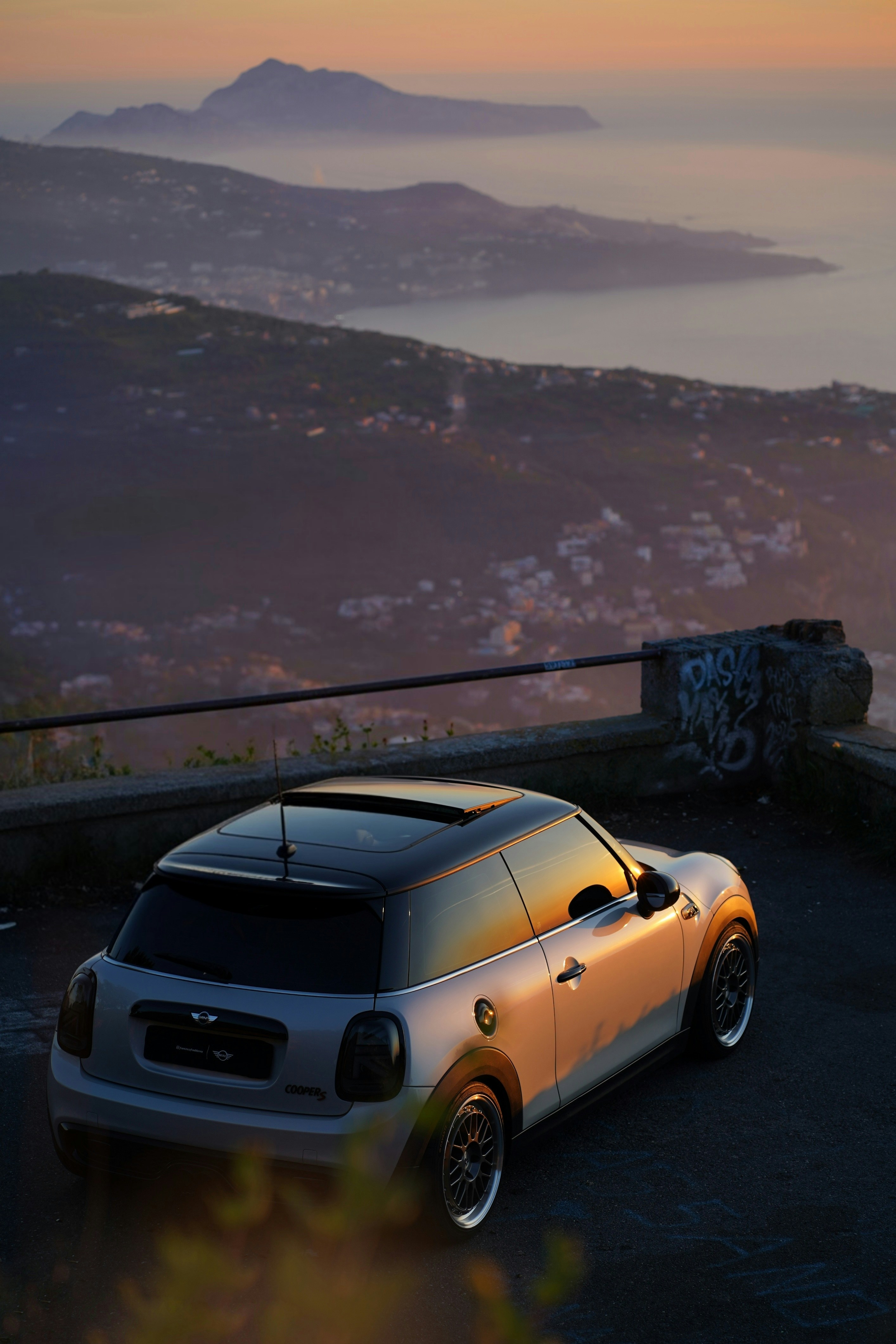 Sunset Over the Coast as Mini Cooper Resting on a Cliff