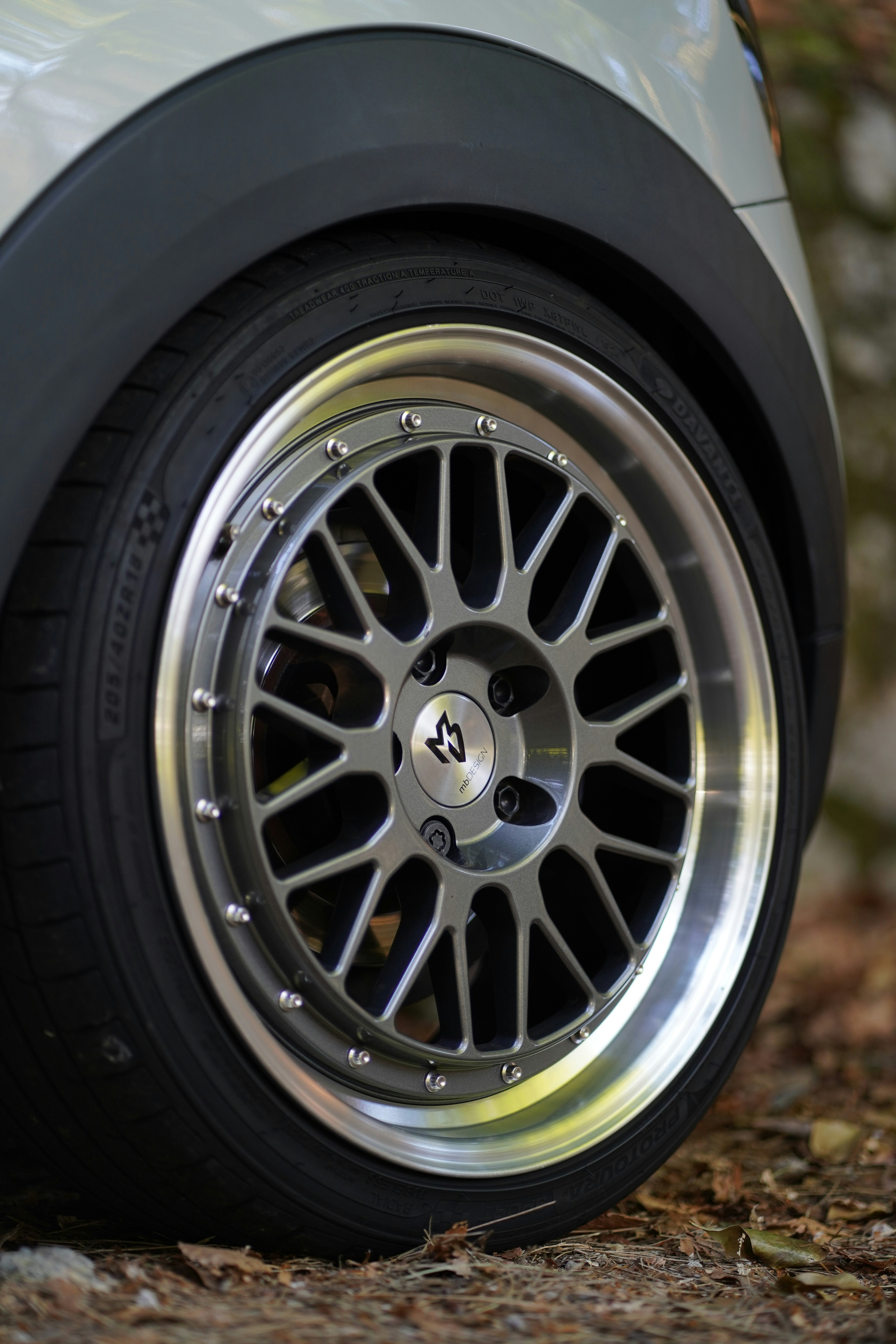 Silver spoke mosaic: a close view of the car’s wheel and hub