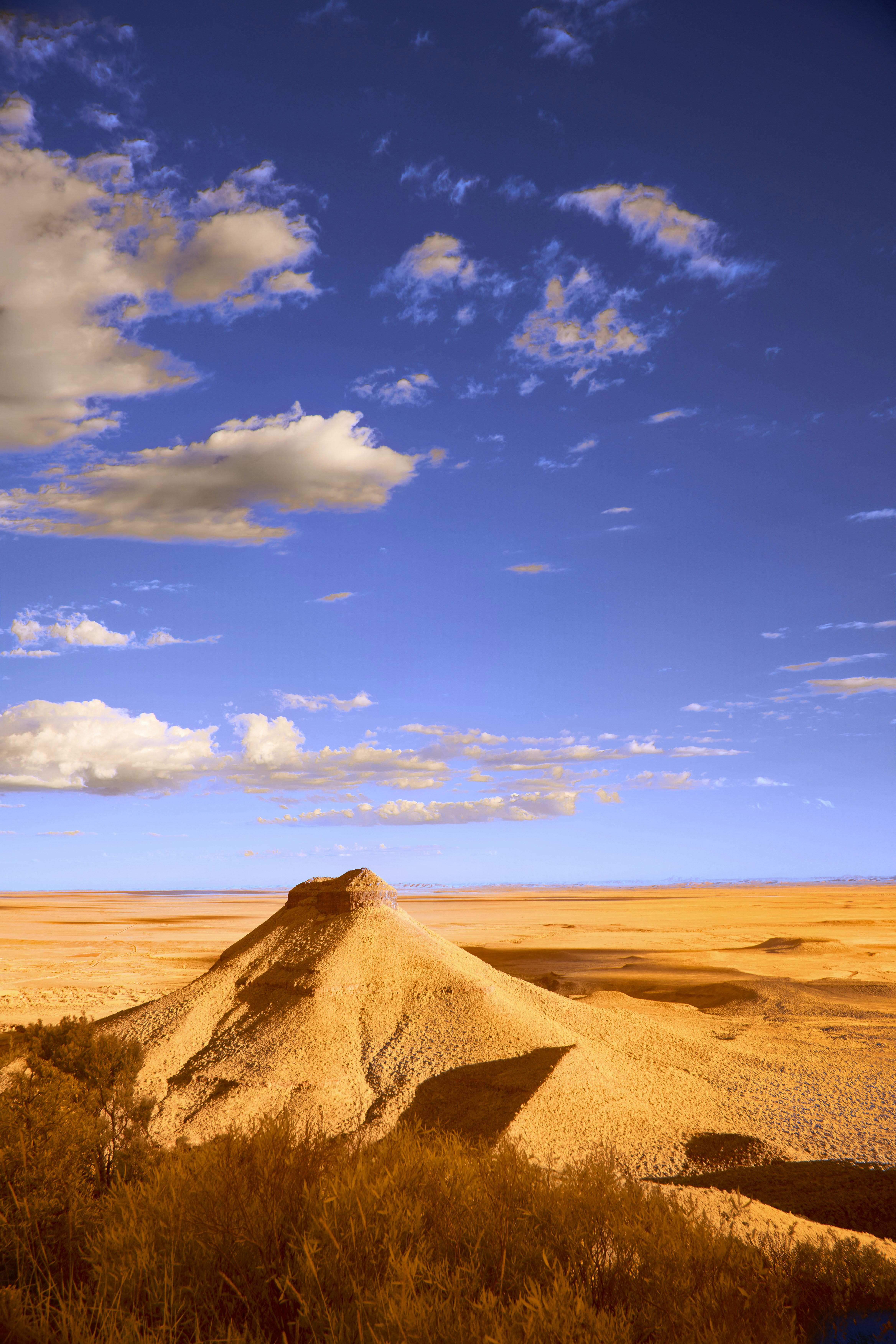 Desert Cone Under a Sky of Cotton Clouds