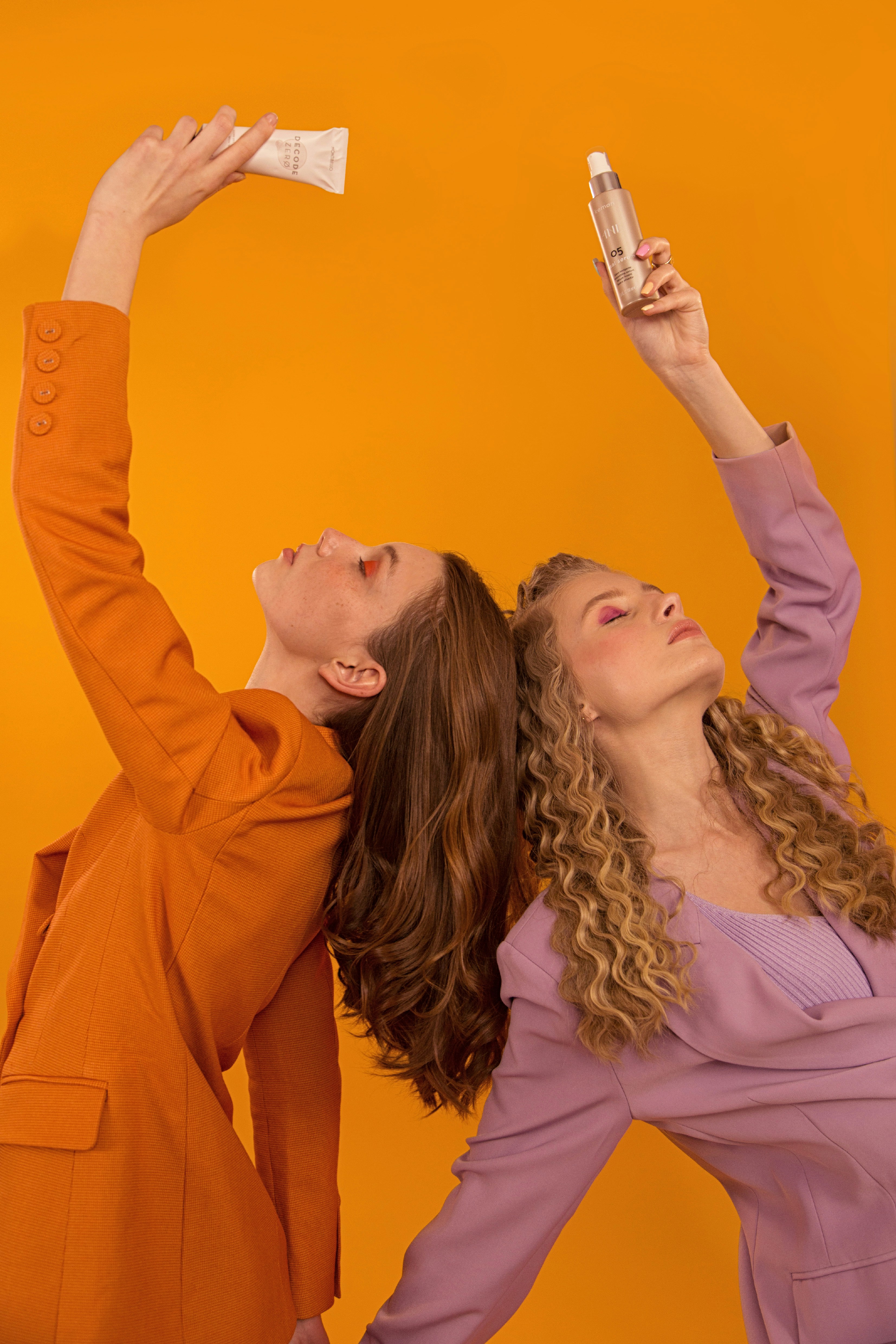Colorful Duo: Opposing Reaches Toward the Spray in a Bright Orange Studio