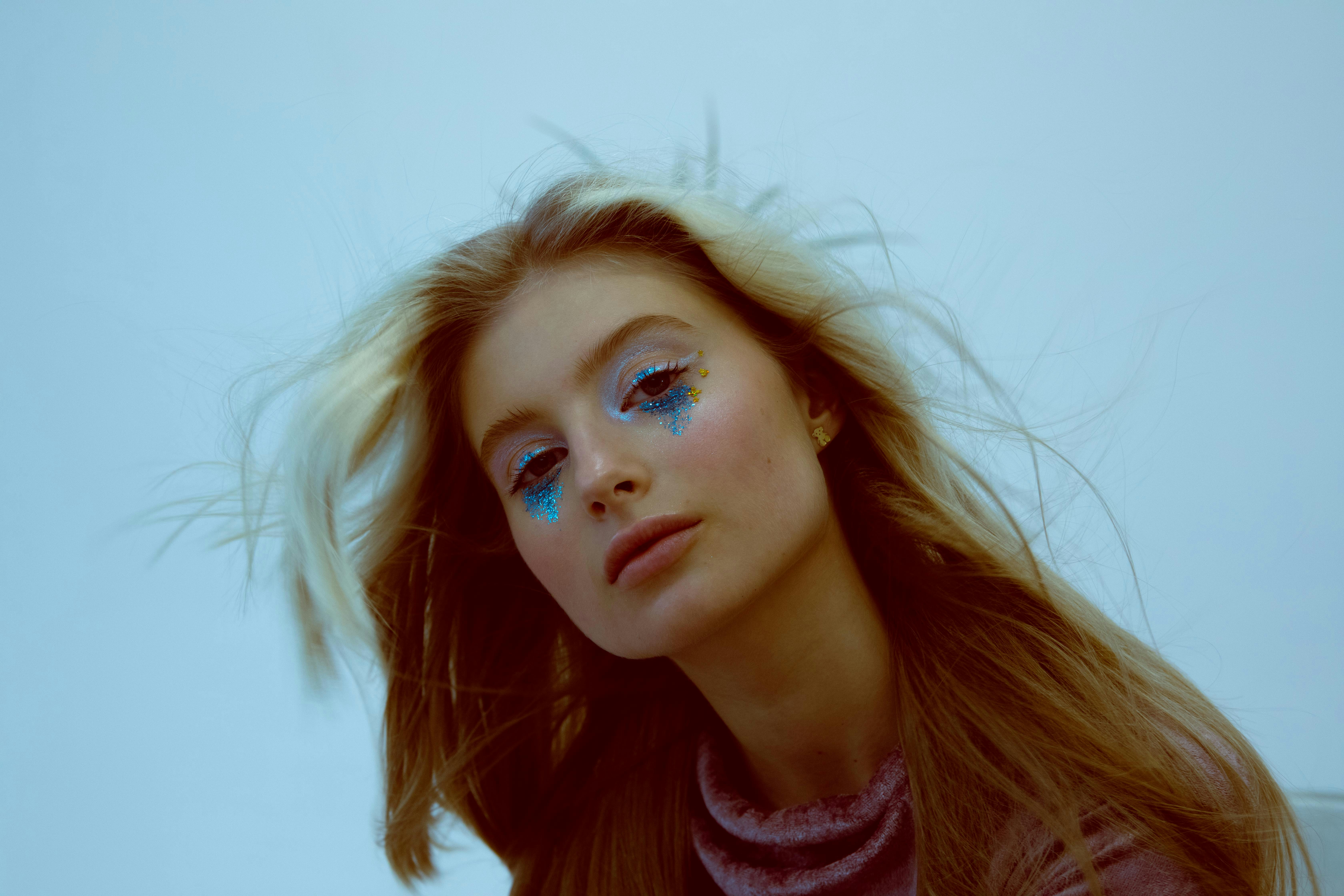Wind-kissed Portrait: Youthful Gaze Under Soft Blue Light