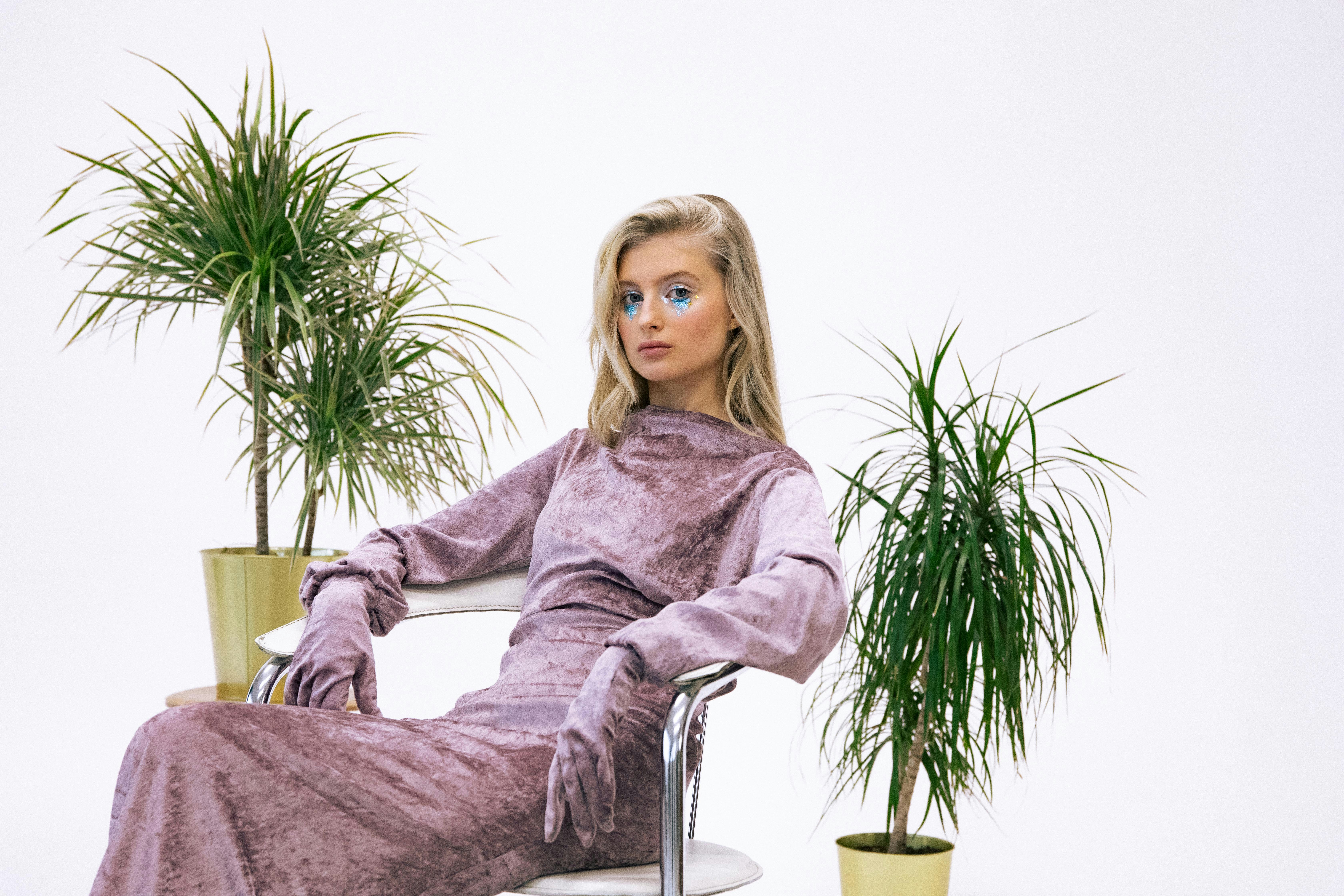 Portrait in Soft Lilac: A poised sitter between potted greens