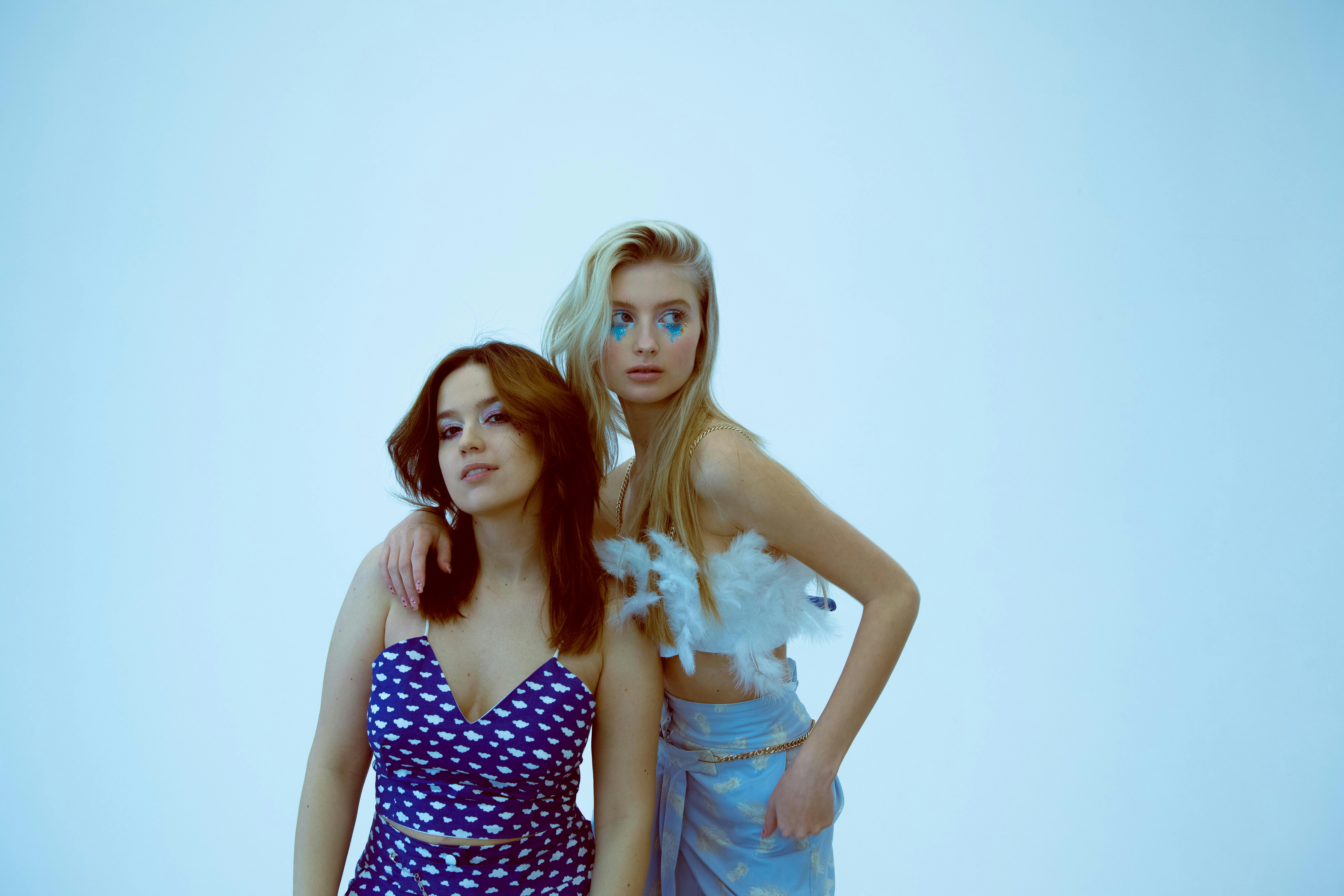 Duo in Soft Blue: Portrait of Confidence Against a Pale Backdrop