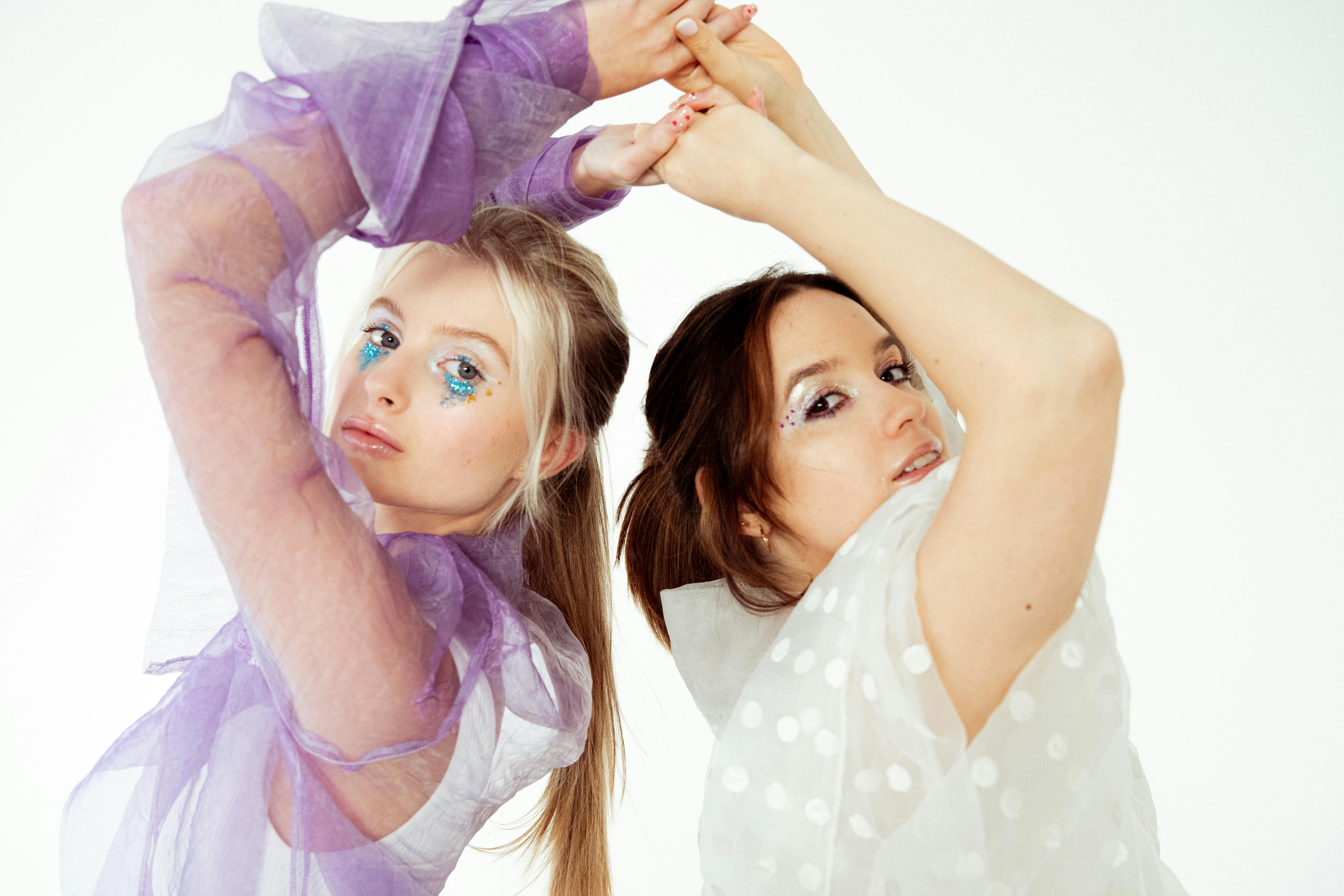 Twin poses, mirrored energy: dancers with sheer lavender and polka-dot fabrics