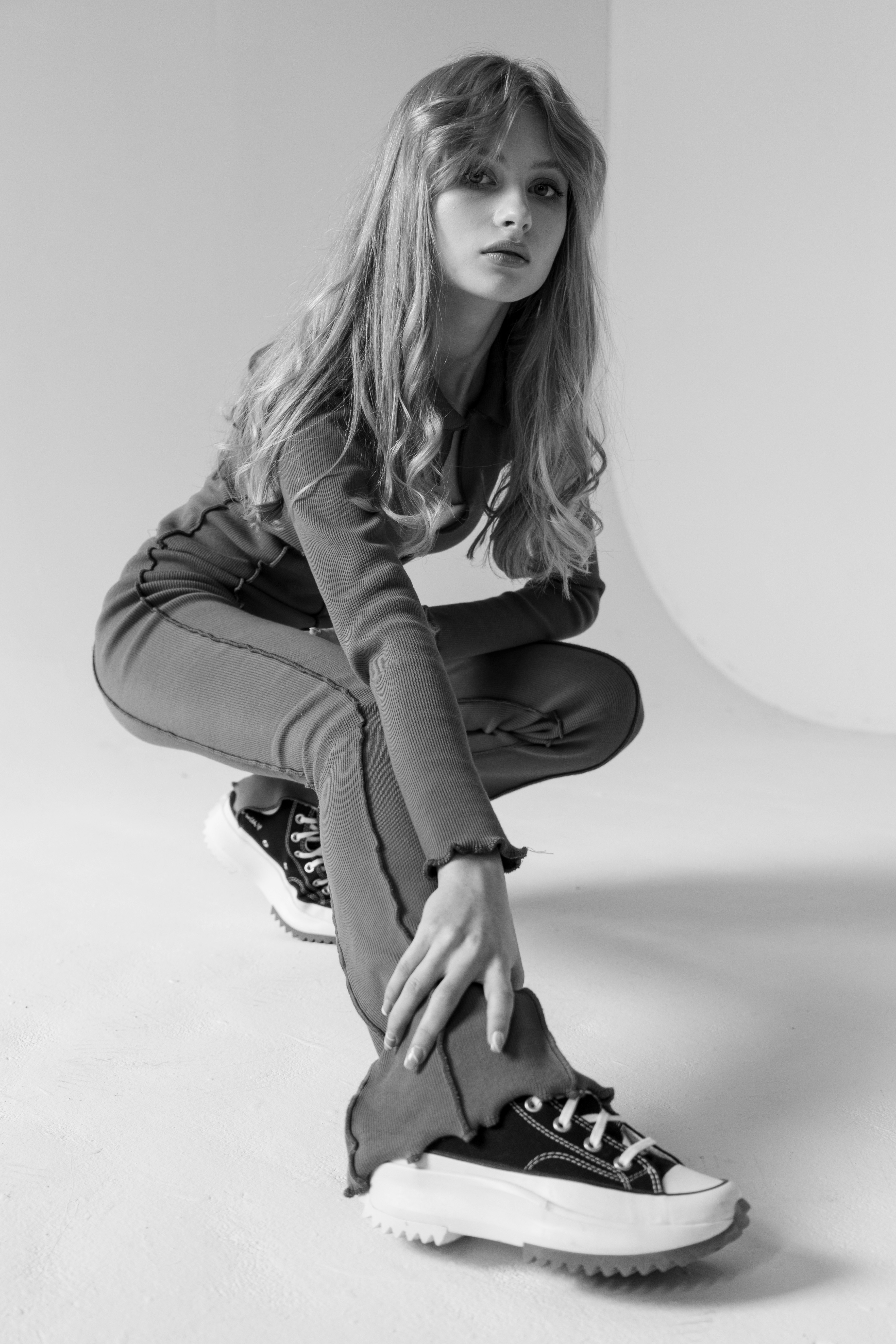Grayscale Studio Gaze: A Youthful Squat in Converse