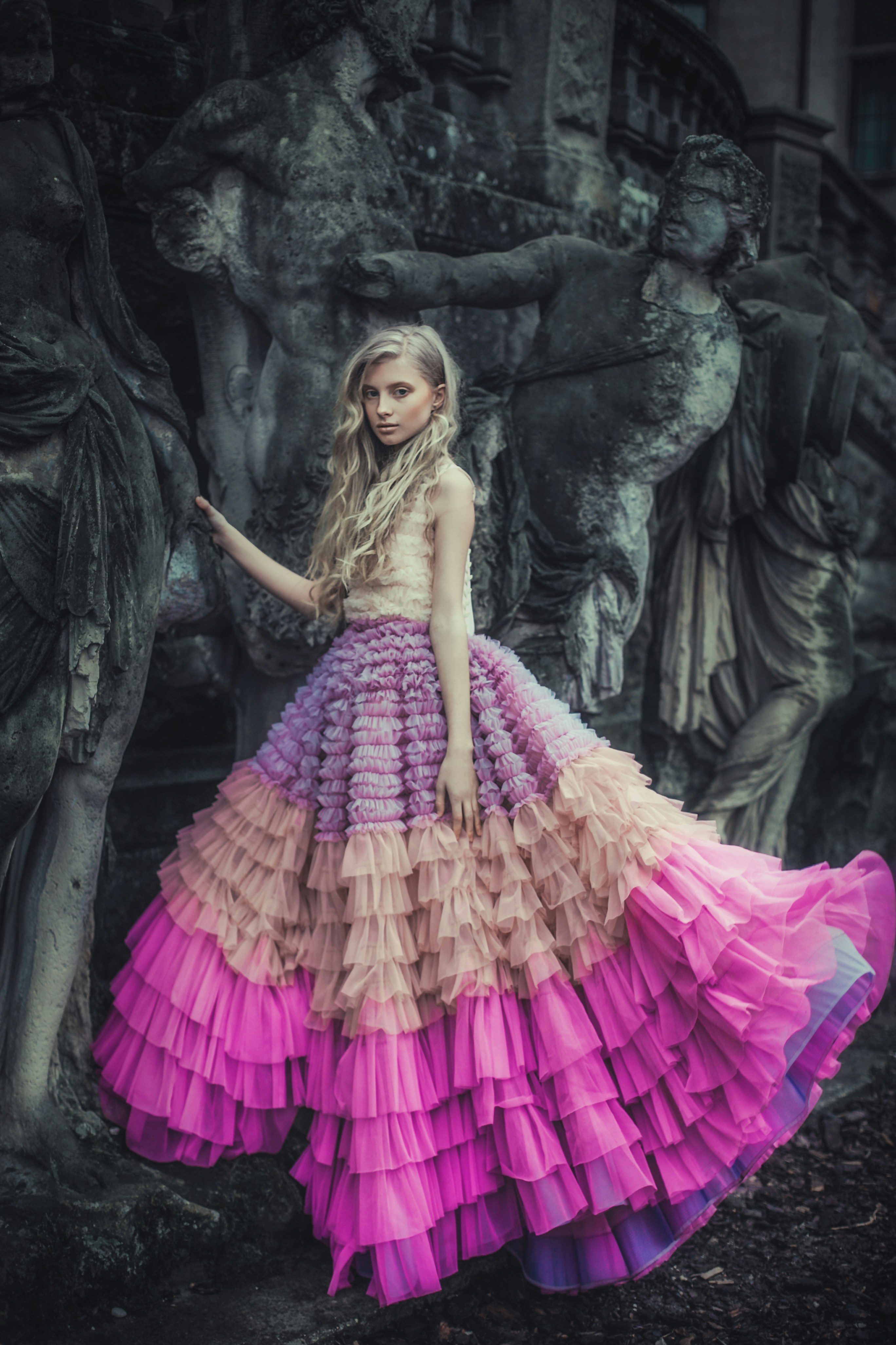Gown of Petals: A Blonde Figure Amid Stone Carvings