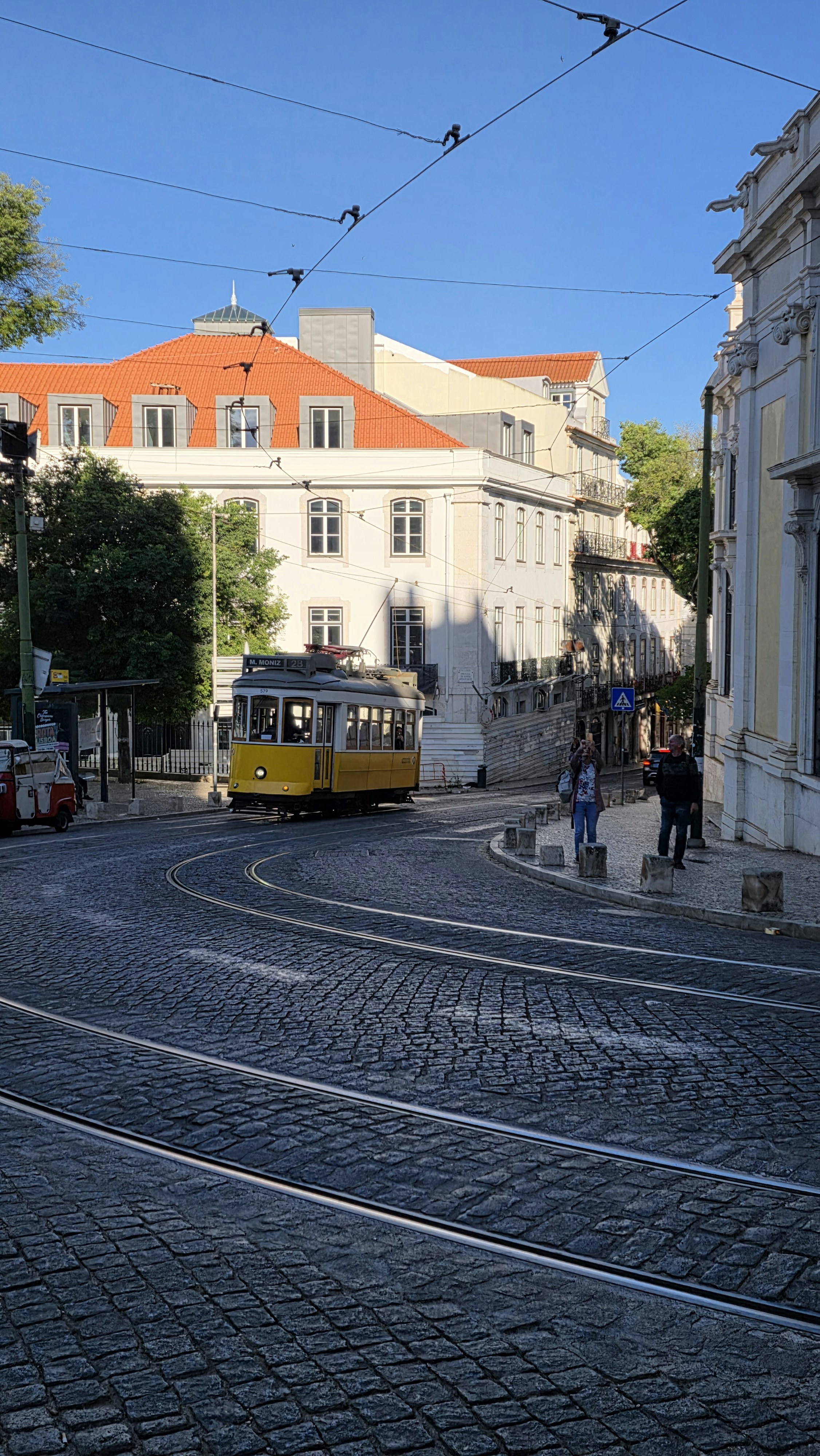 Yellow tram gliding through a sunlit European street
