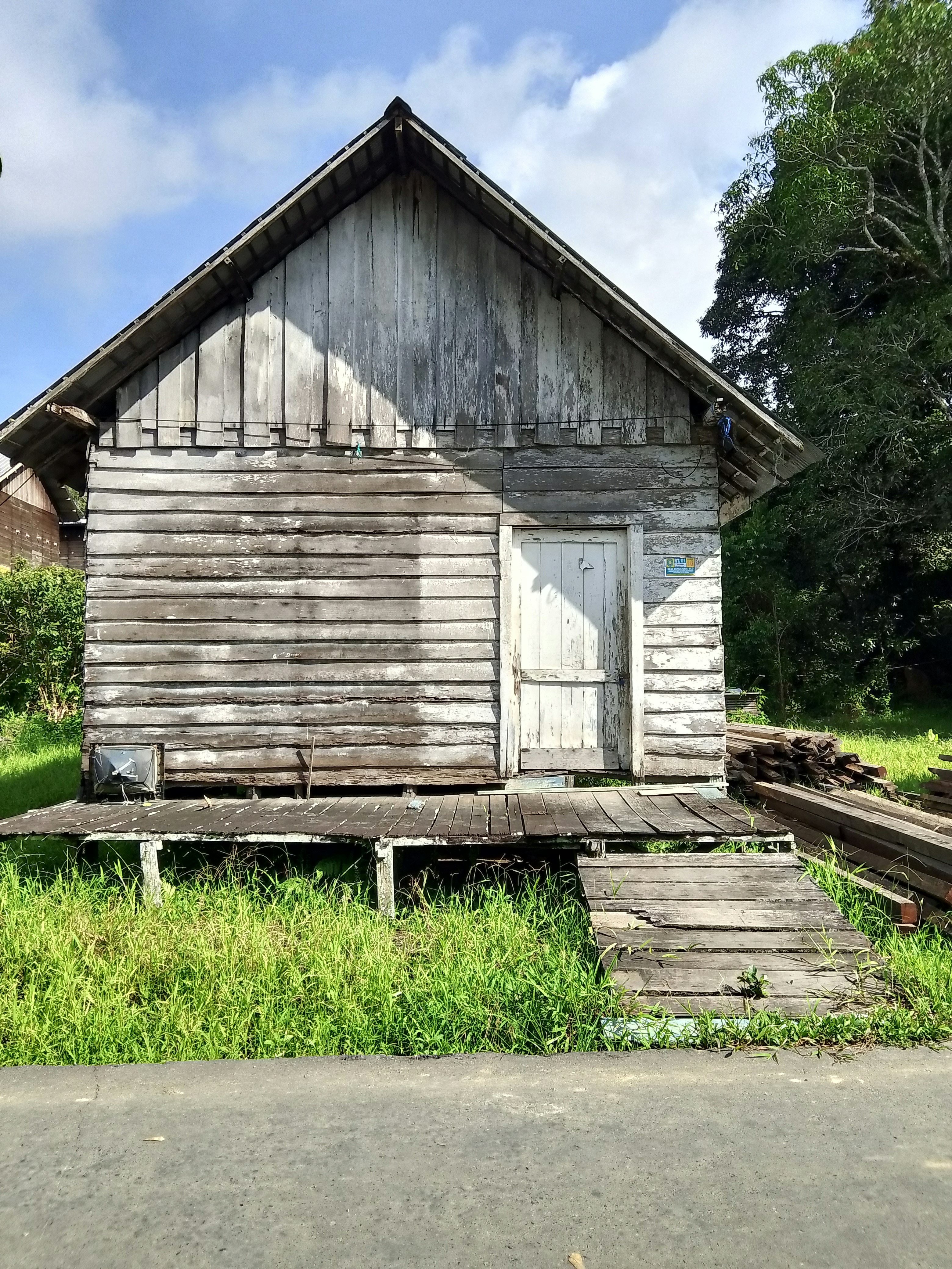 Rustic wooden shack with a white door and green grass.