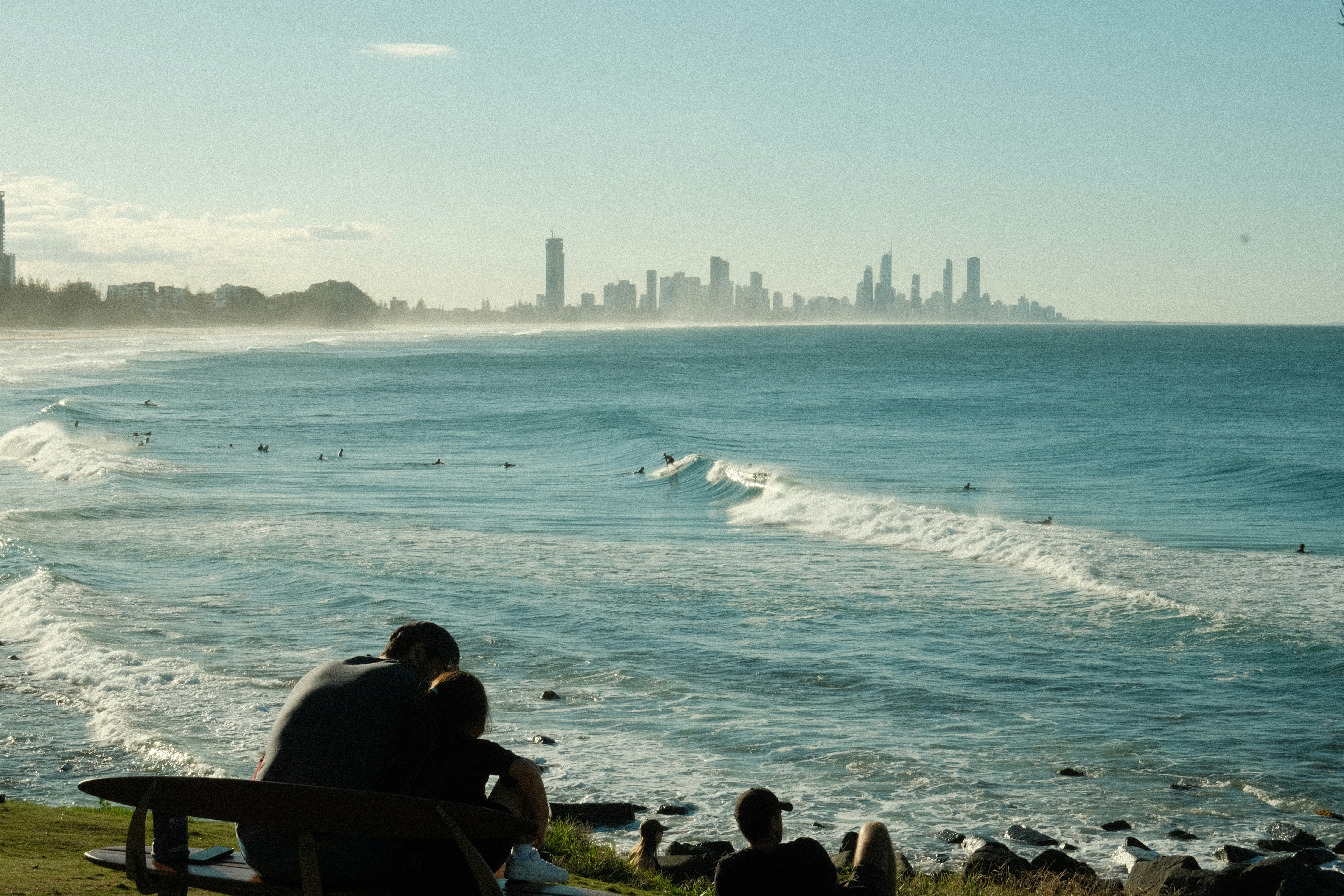 Sunlit Coastline: Families and Foam Along a Golden Beach