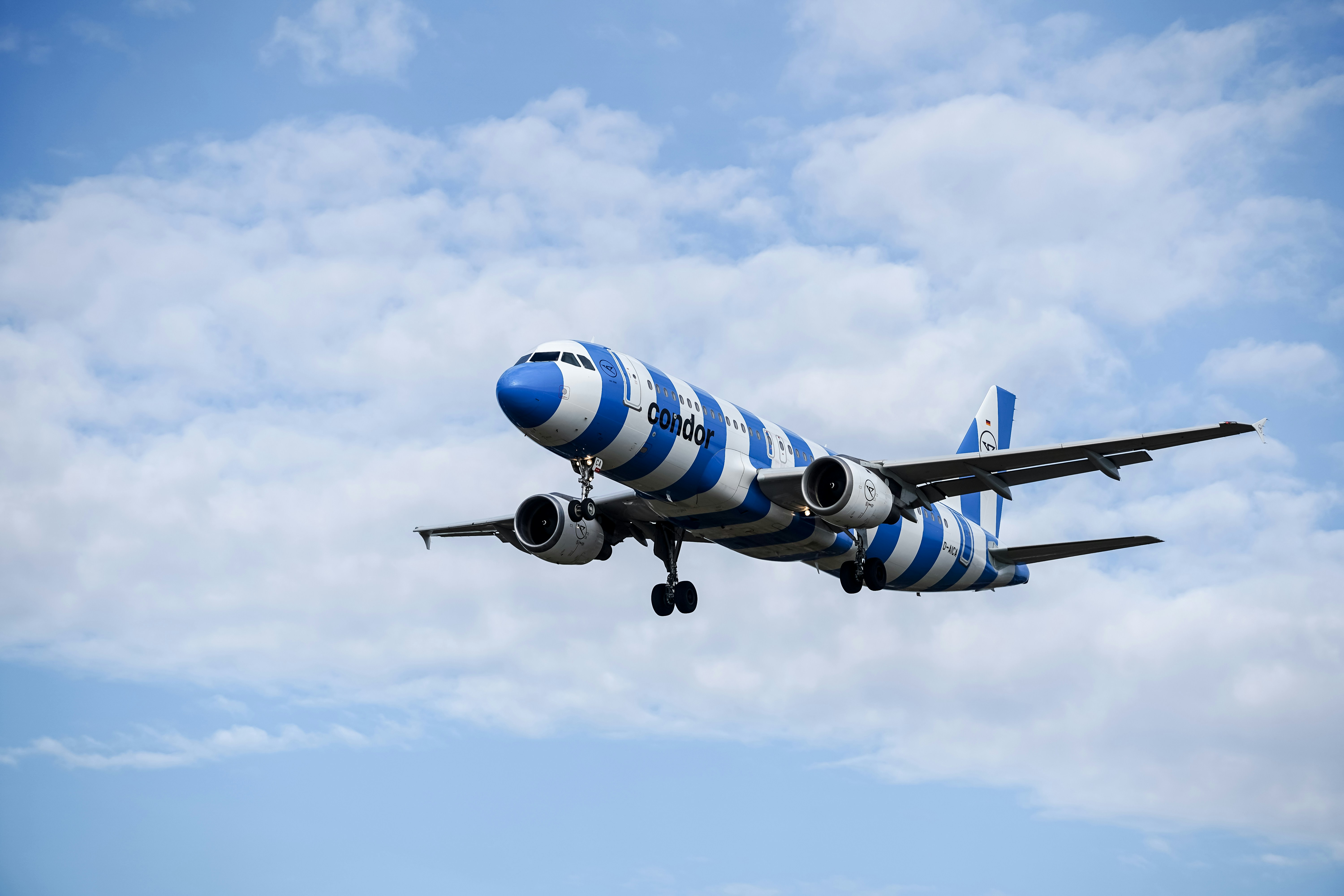  striped airliner gliding through a bright sky