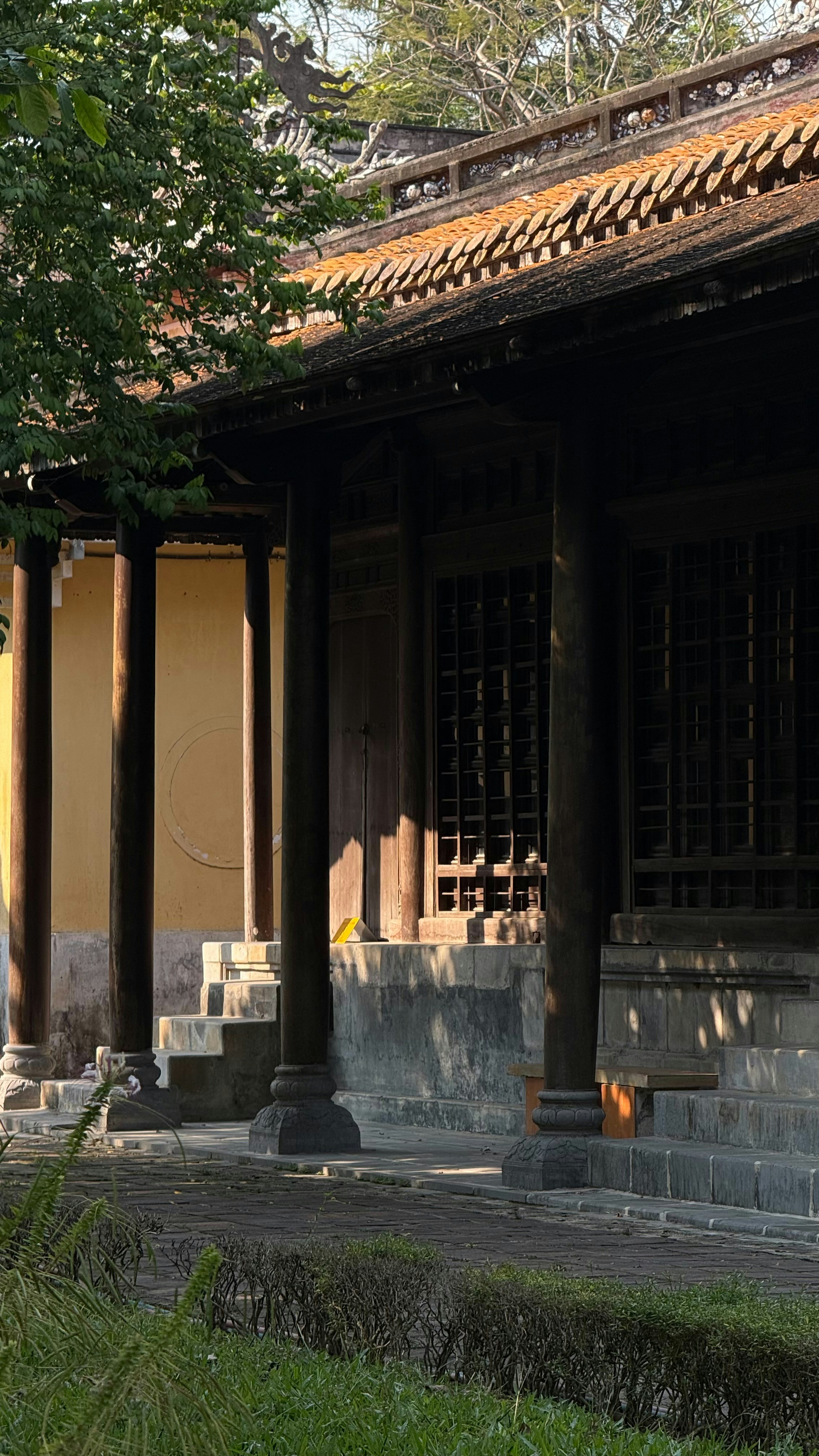 Sunlit Columns and Traditional Roof: A Quiet Courtyard Scene