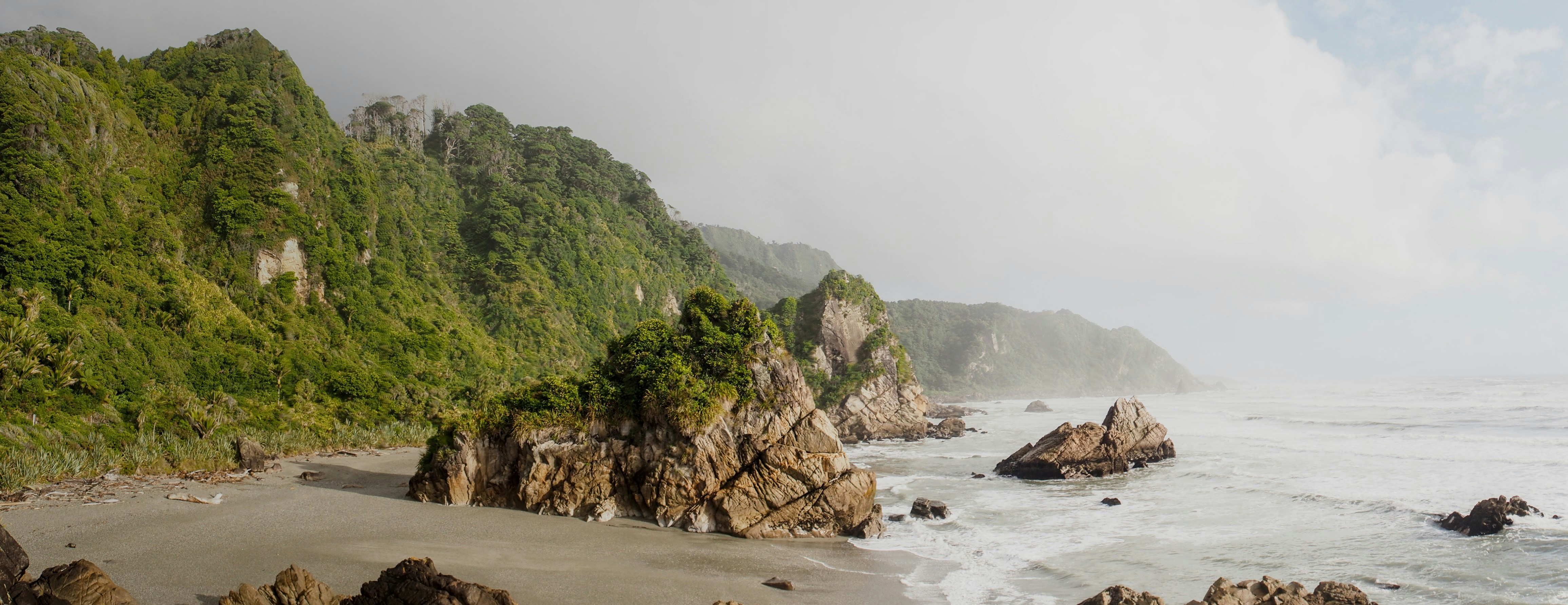 Coastal Cliffs Rise from Misty Surf
